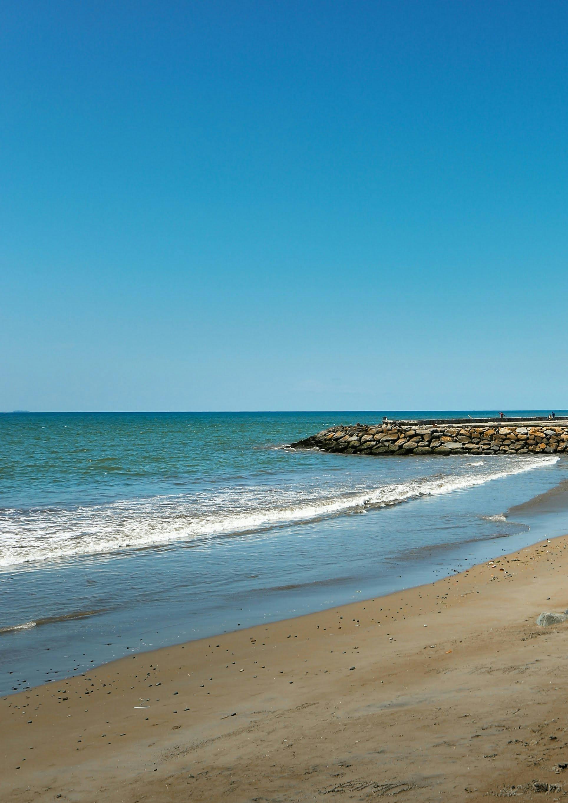 Brown Sand Beach with Breakwater · Free Stock Photo