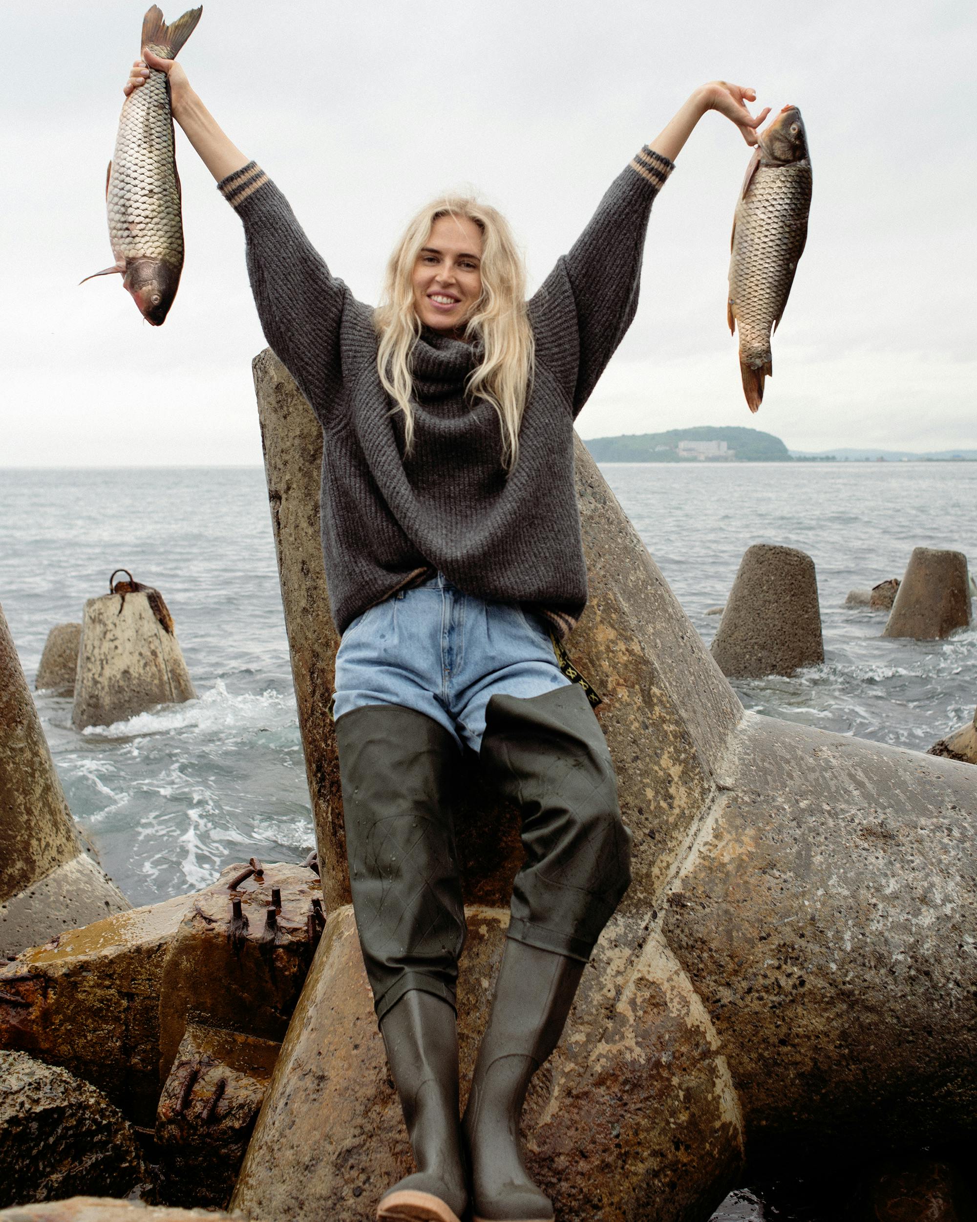 Woman Standing on a Seashore Holding Two Large Fish in Hands · Free ...