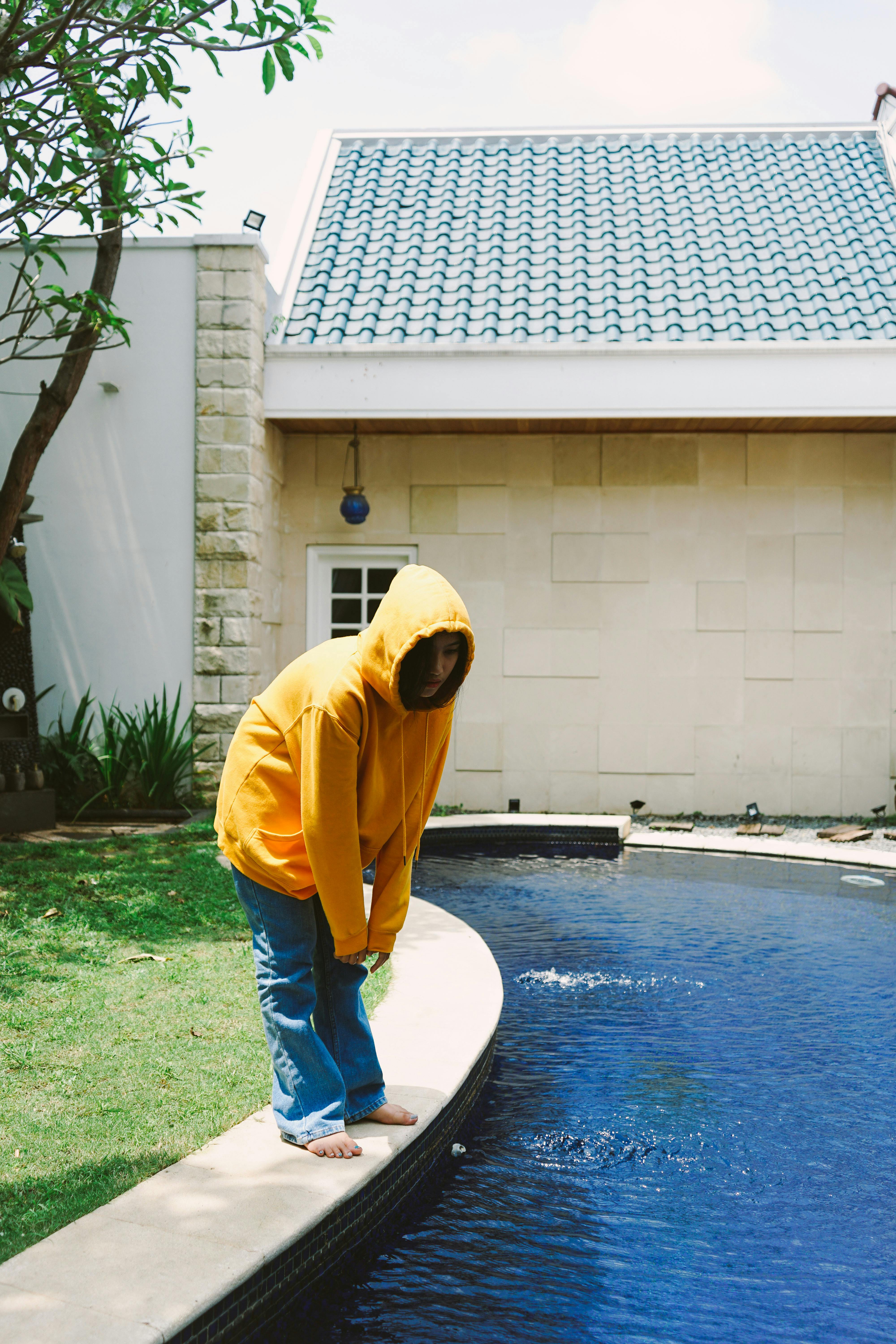 Person in Yellow Hoodie Sweater Standing Near the Swimming Pool · Free ...