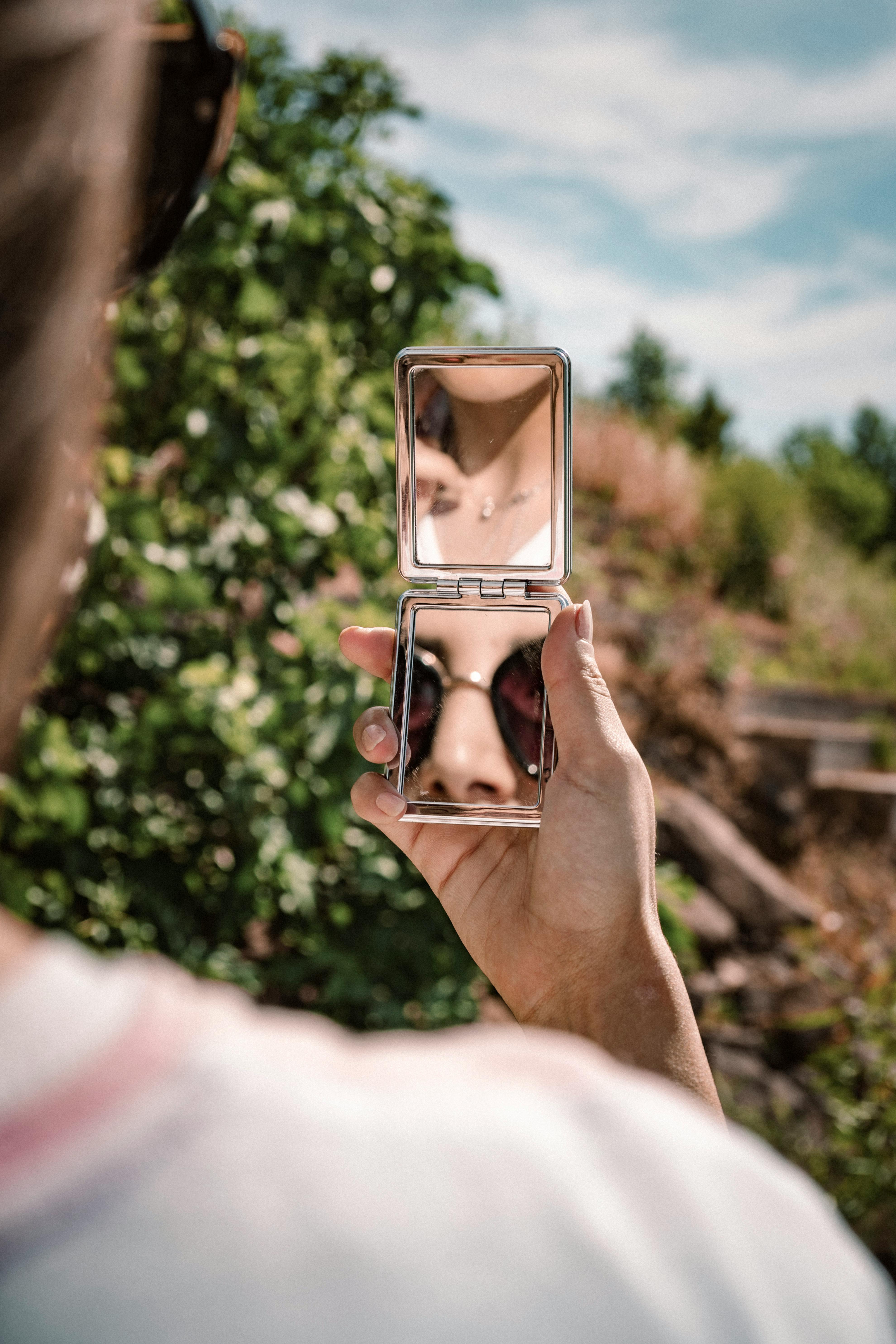 Close-Up Shot of a Person Holding a Pocket Mirror · Free Stock Photo