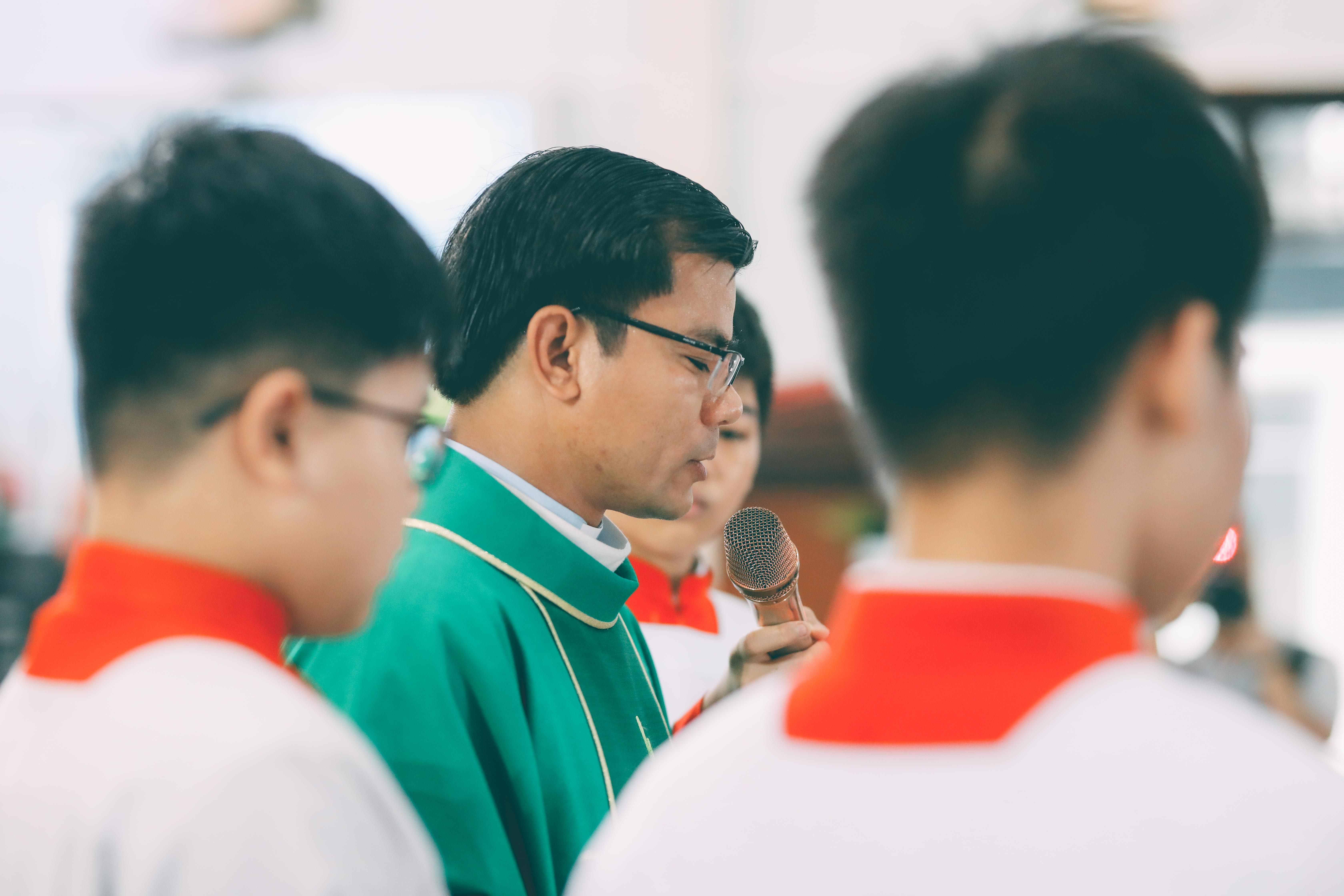Priest During a Mass Holding the Host · Free Stock Photo