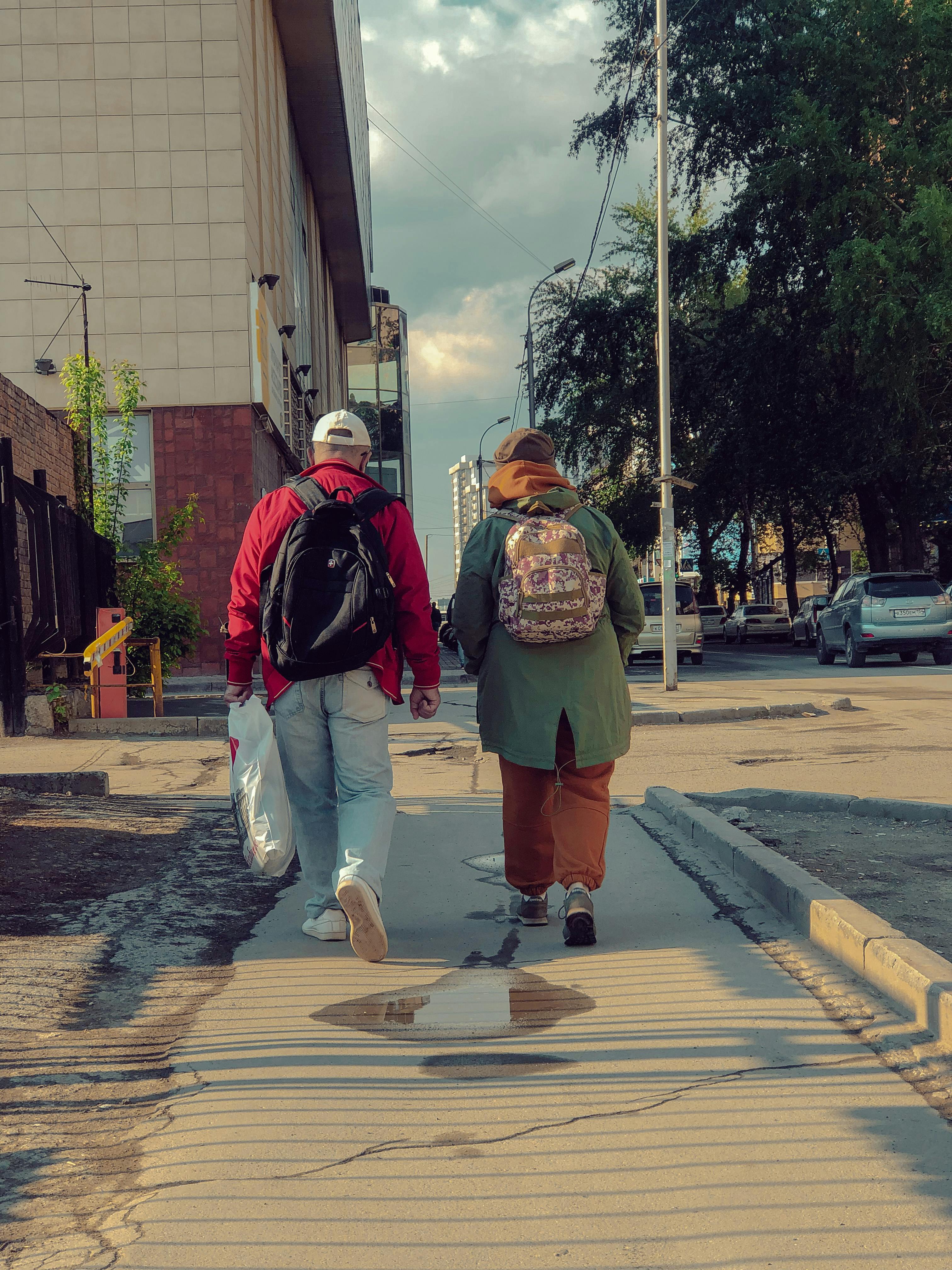 Back View of Man and Woman Walking on a Sidewalk · Free Stock Photo