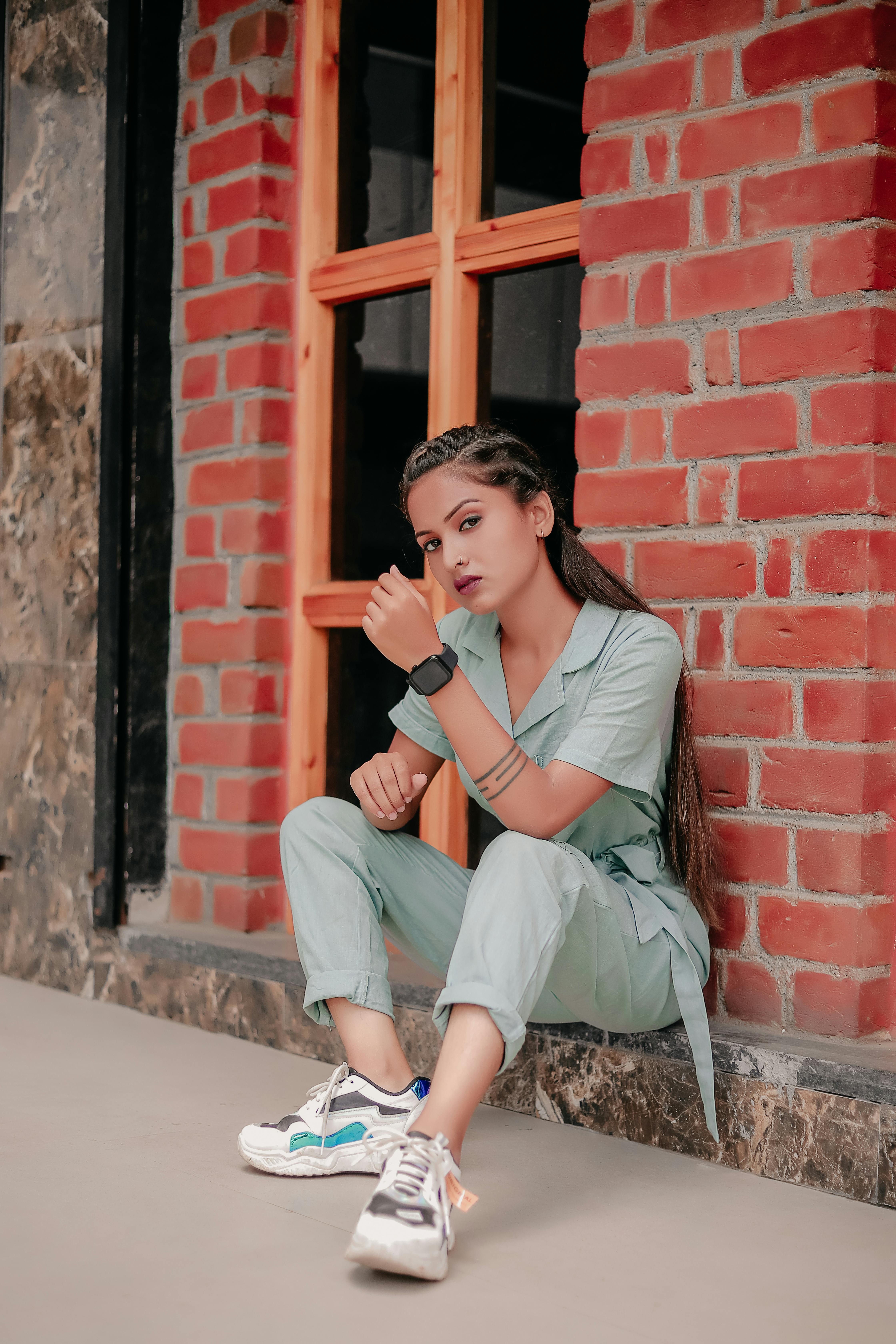 A Woman with Braided Hair Sitting on the Concrete Pavement · Free Stock ...