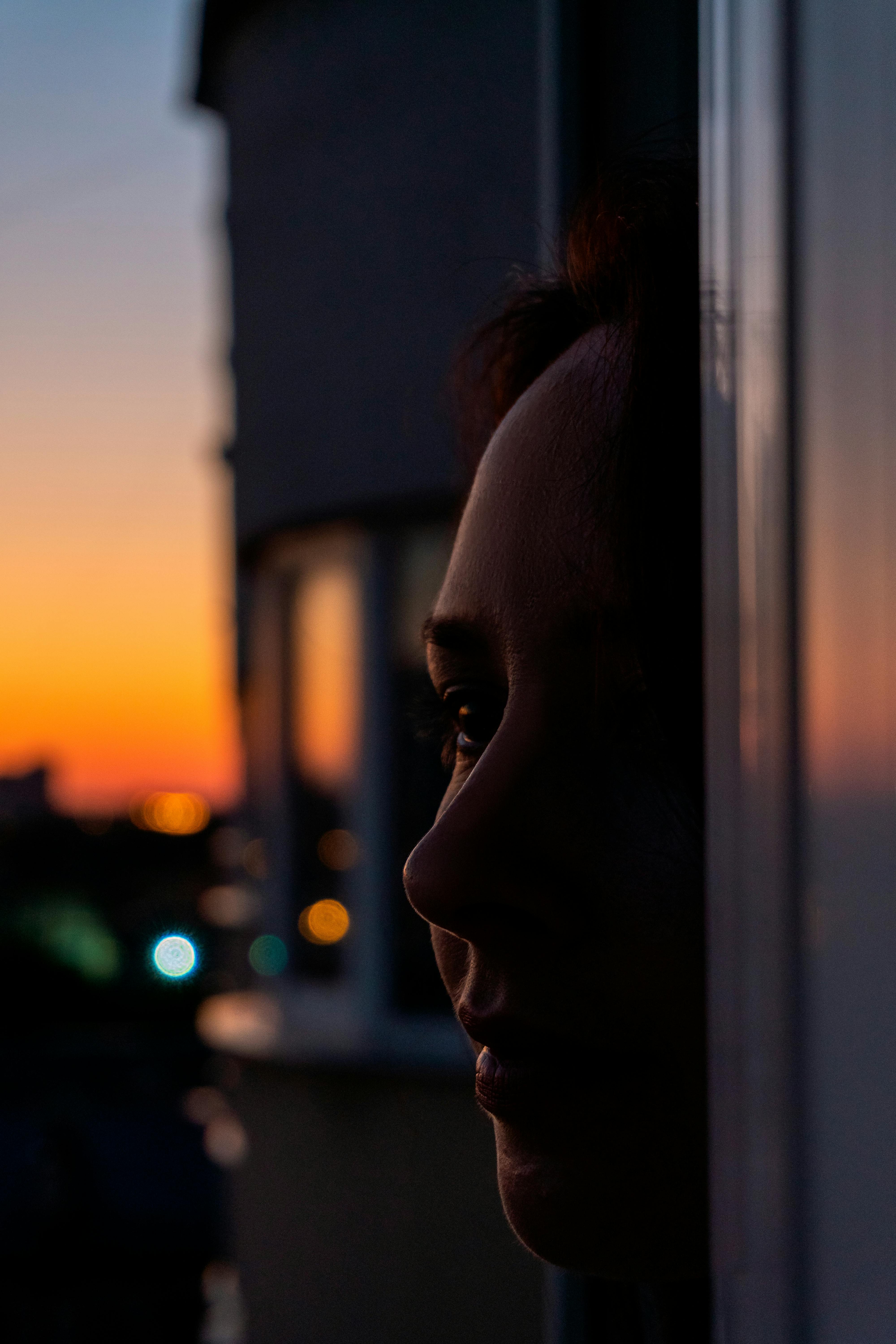 A Person Looking Outside from the Window during Sunset · Free Stock Photo