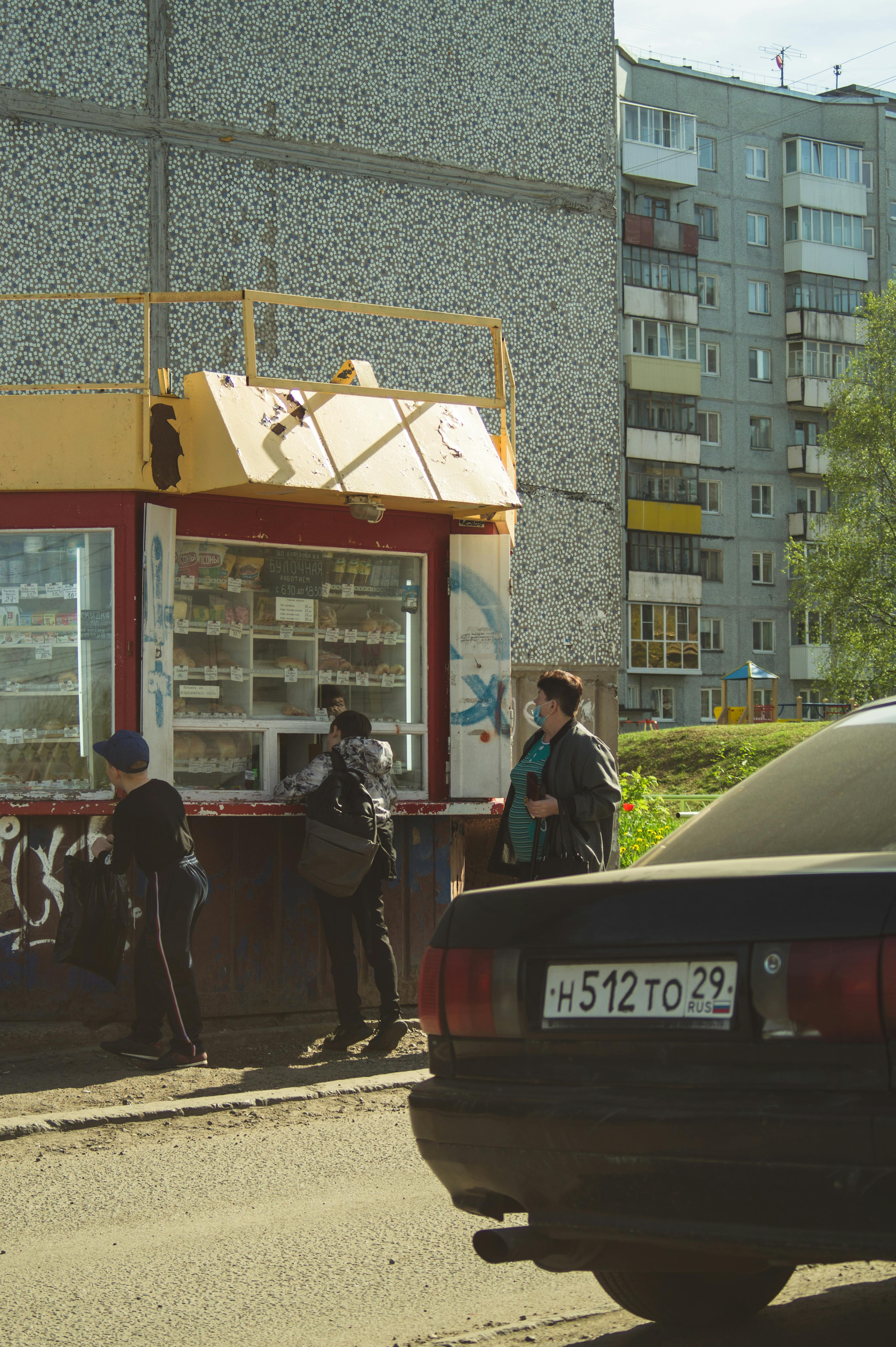 People Standing in Front of a Stall Near a Building · Free Stock Photo