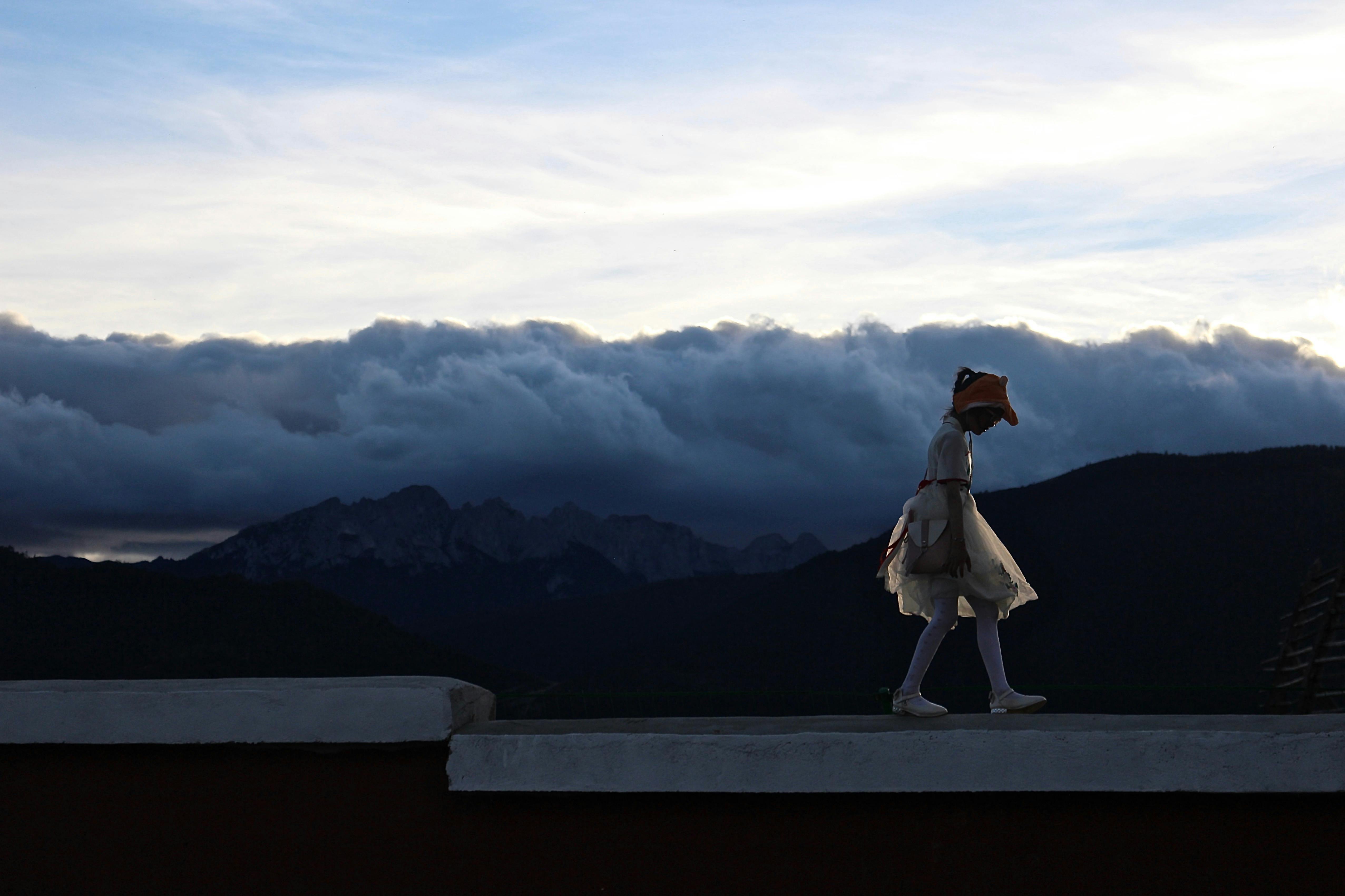 Little Girl in Dress Walking Across Ledge · Free Stock Photo