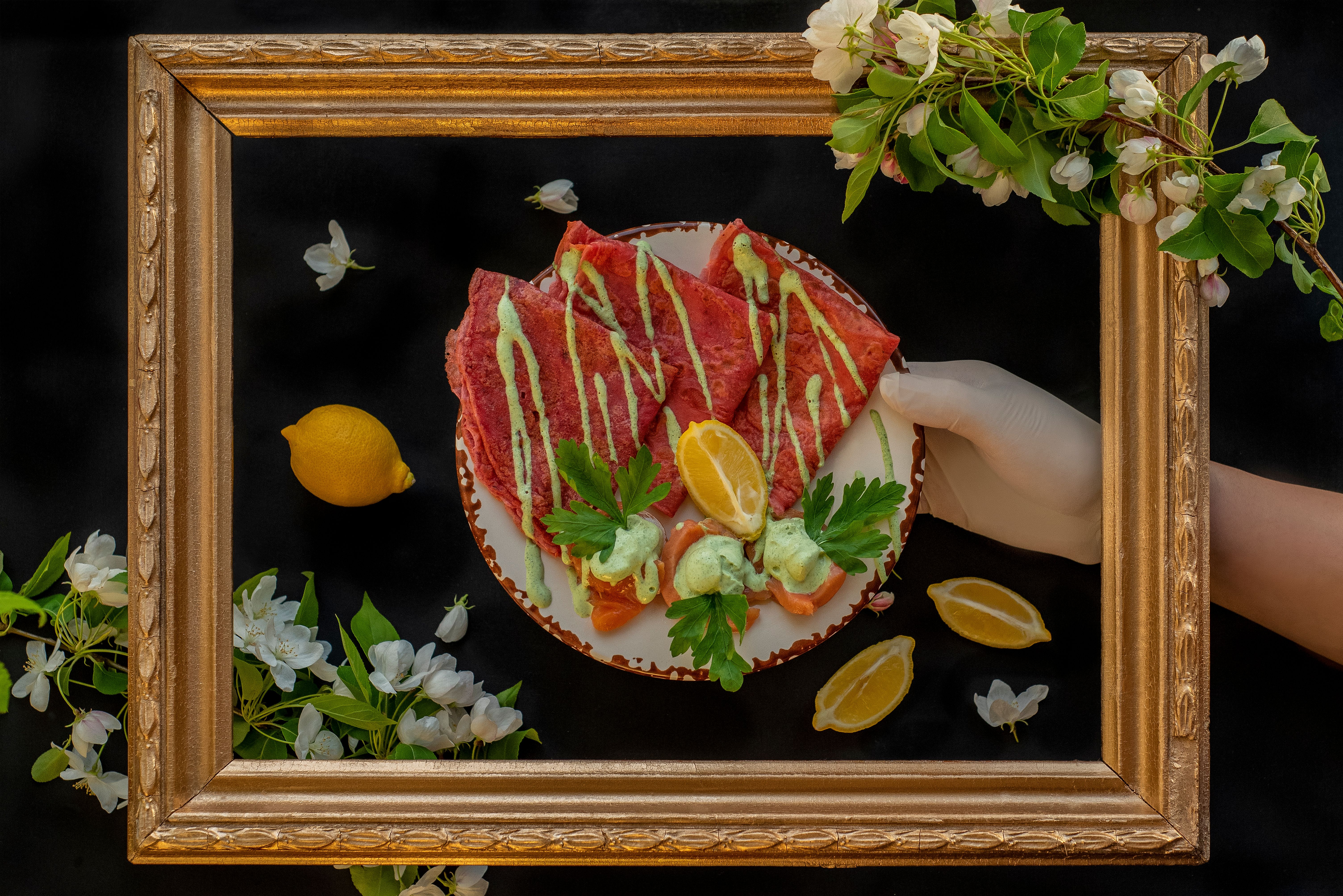 Wooden Frame Behind a Hand Holding a Plate of Food · Free Stock Photo