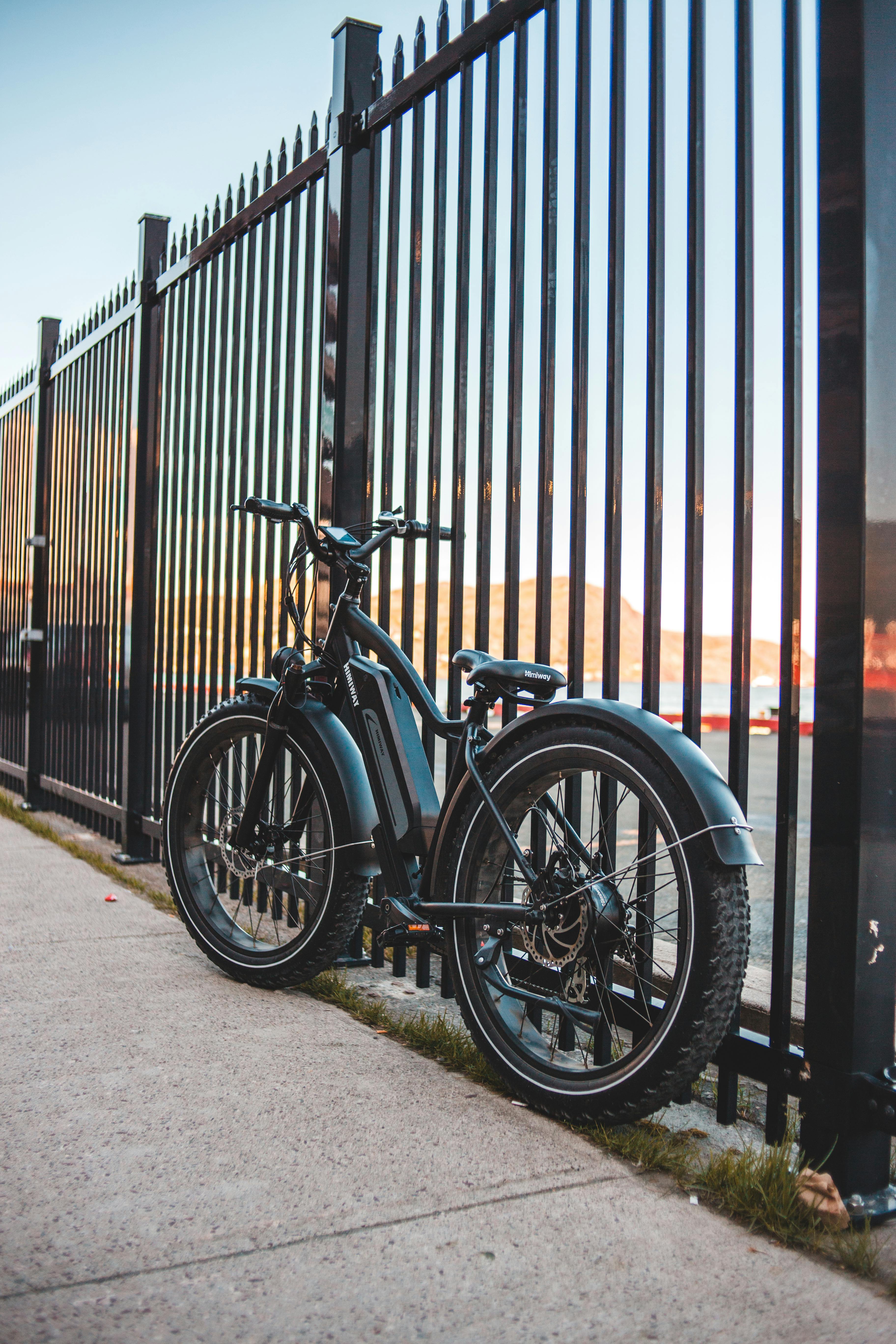A Bicycle Parked Near the Black Metal Gate · Free Stock Photo