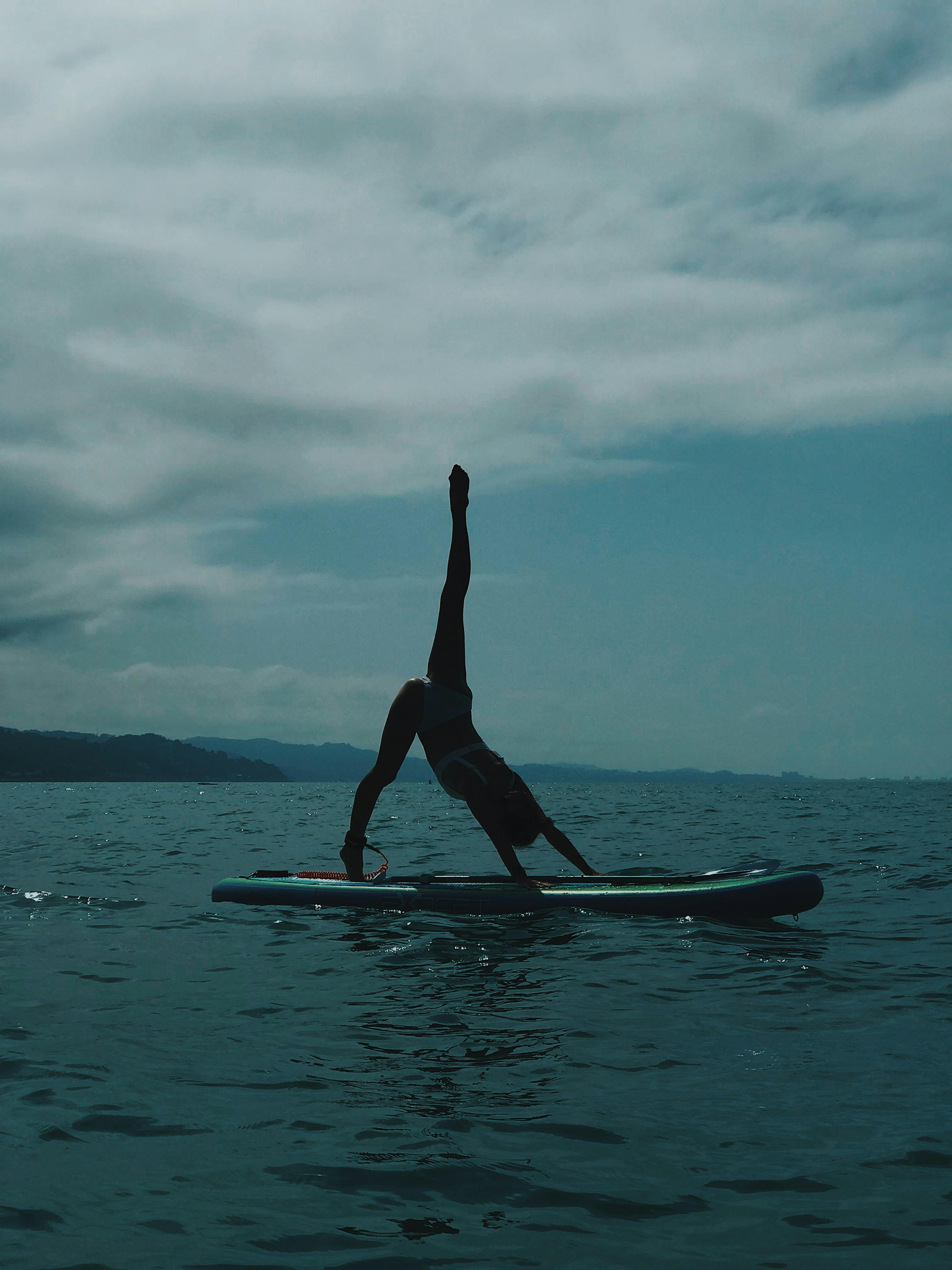 Woman doing Stretching Exercises on a Paddle Board · Free Stock Photo