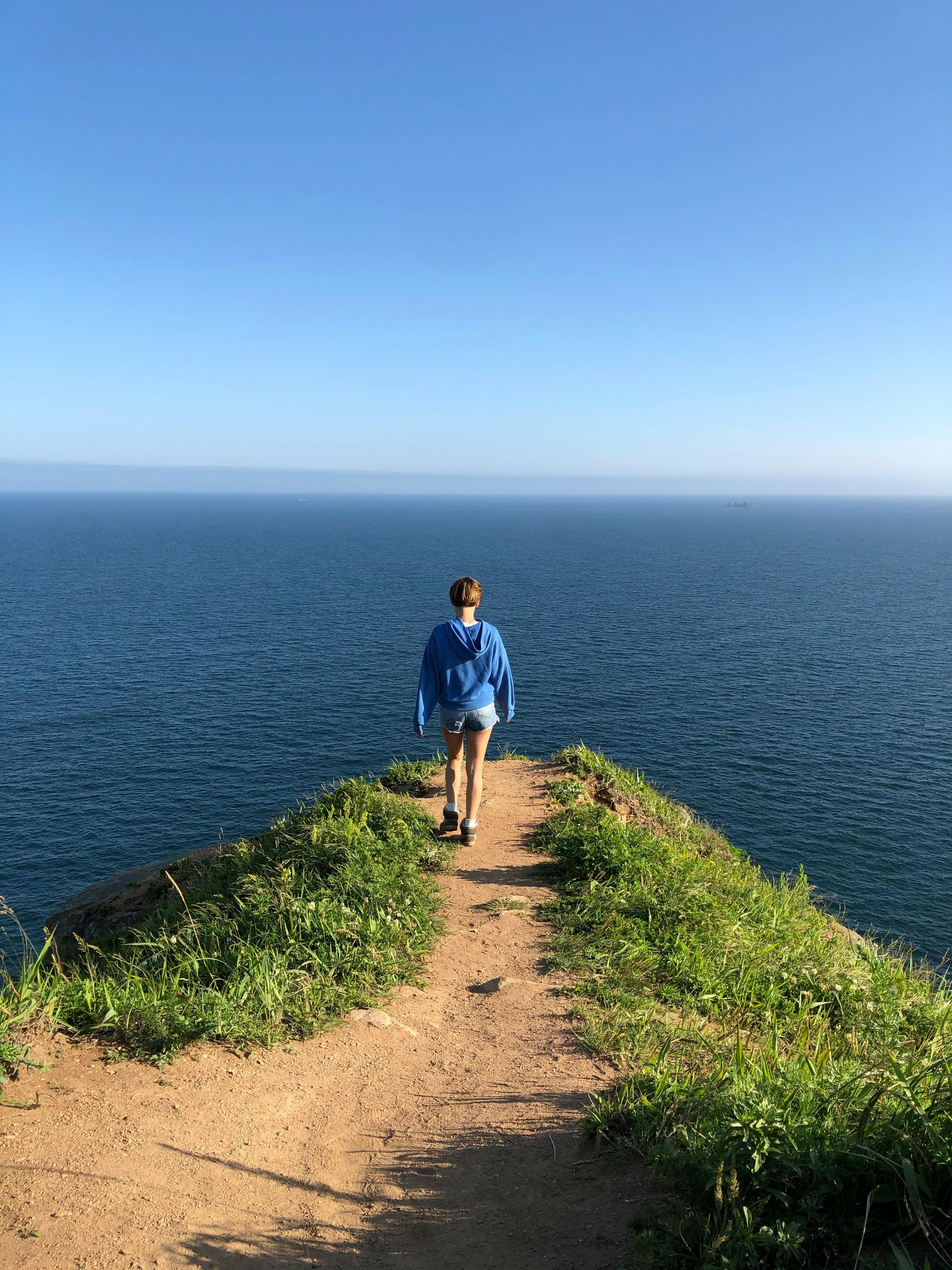 Back View of a Woman on the Edge of a Cliff · Free Stock Photo