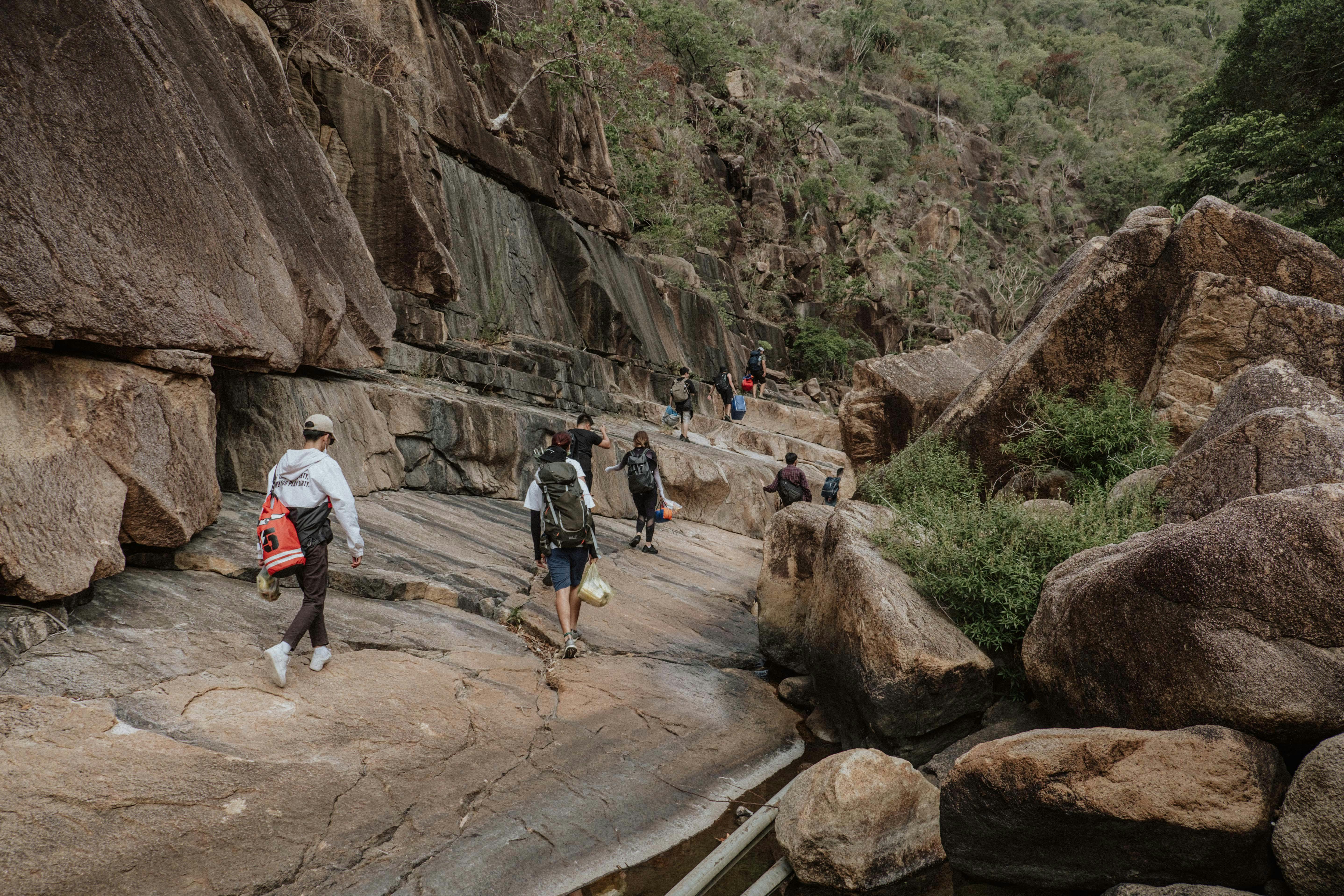 People Walking Massive Rock Surface · Free Stock Photo