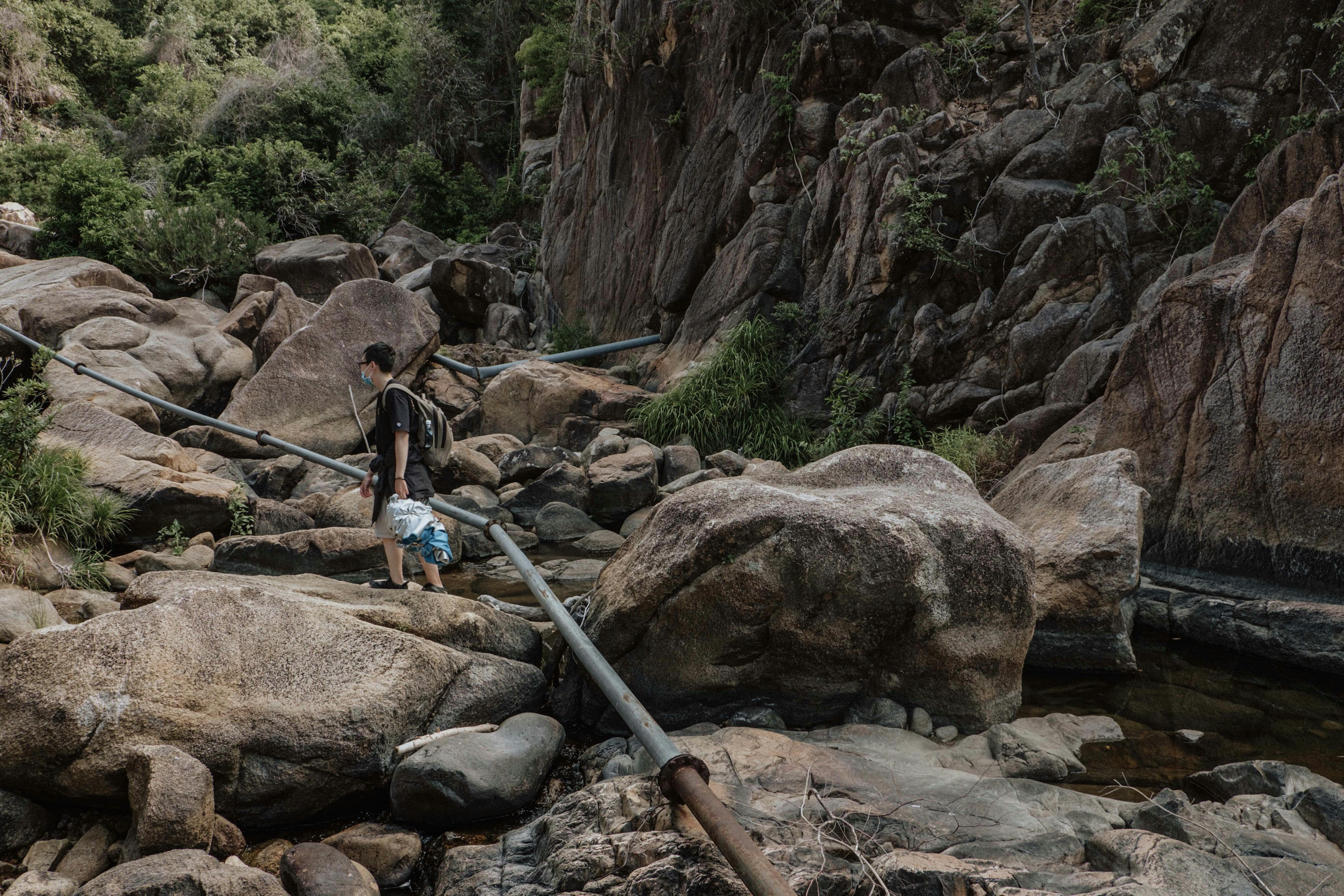 Man Walking Between Big Rocks in Mountains · Free Stock Photo