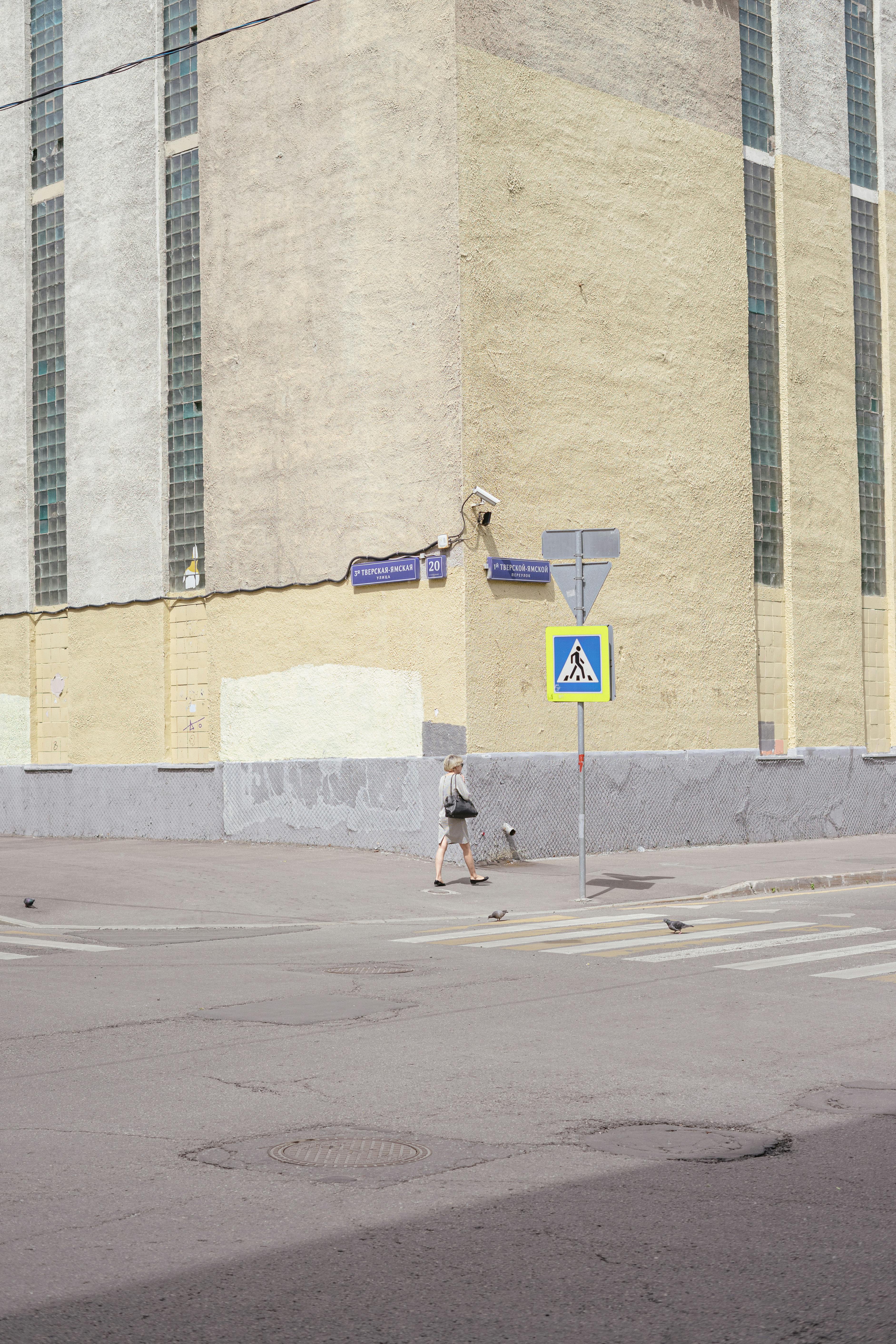 Woman Walking in the Side Walk on the Corner of the Building · Free ...