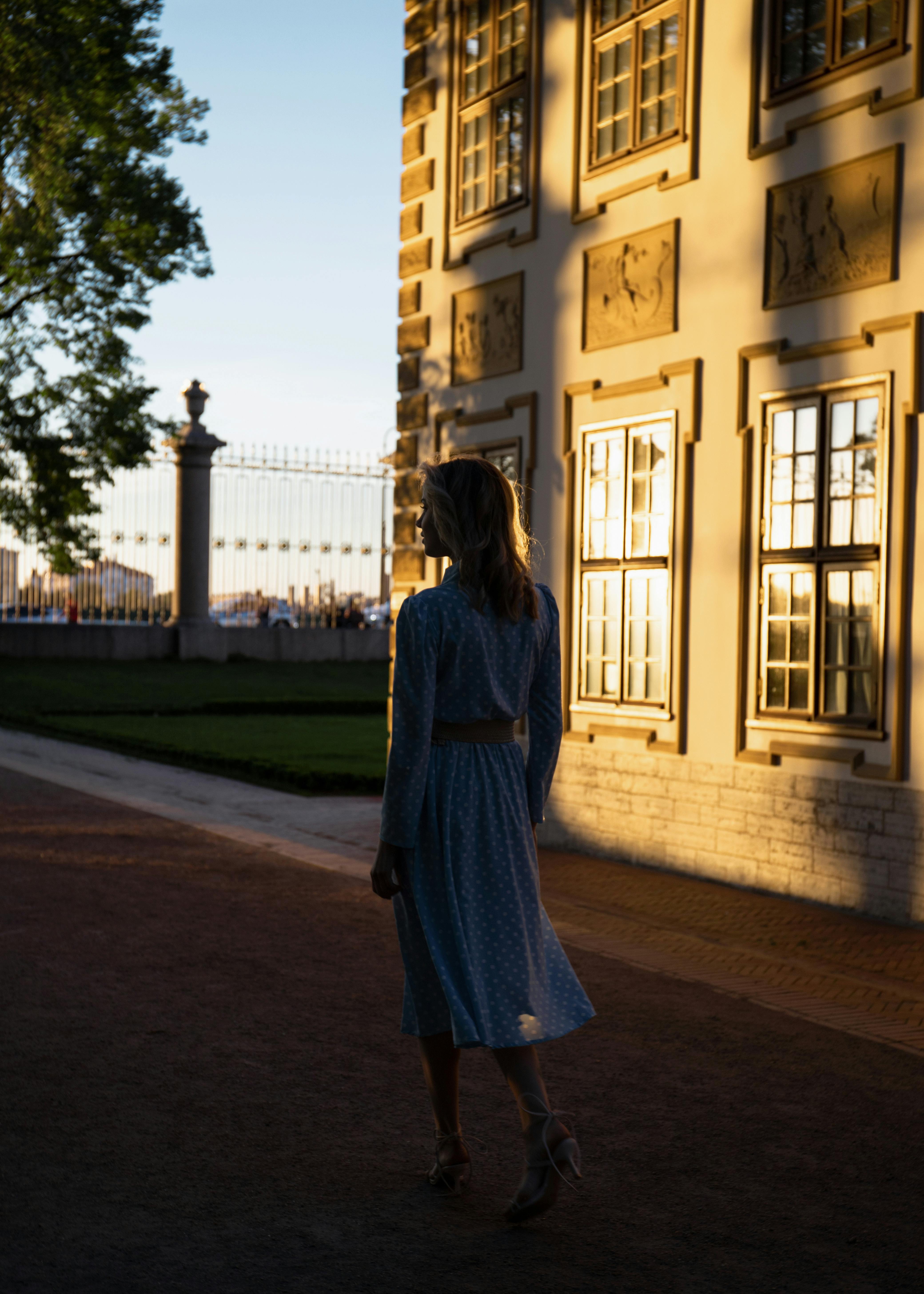 Woman Walking near an Architectural Building · Free Stock Photo