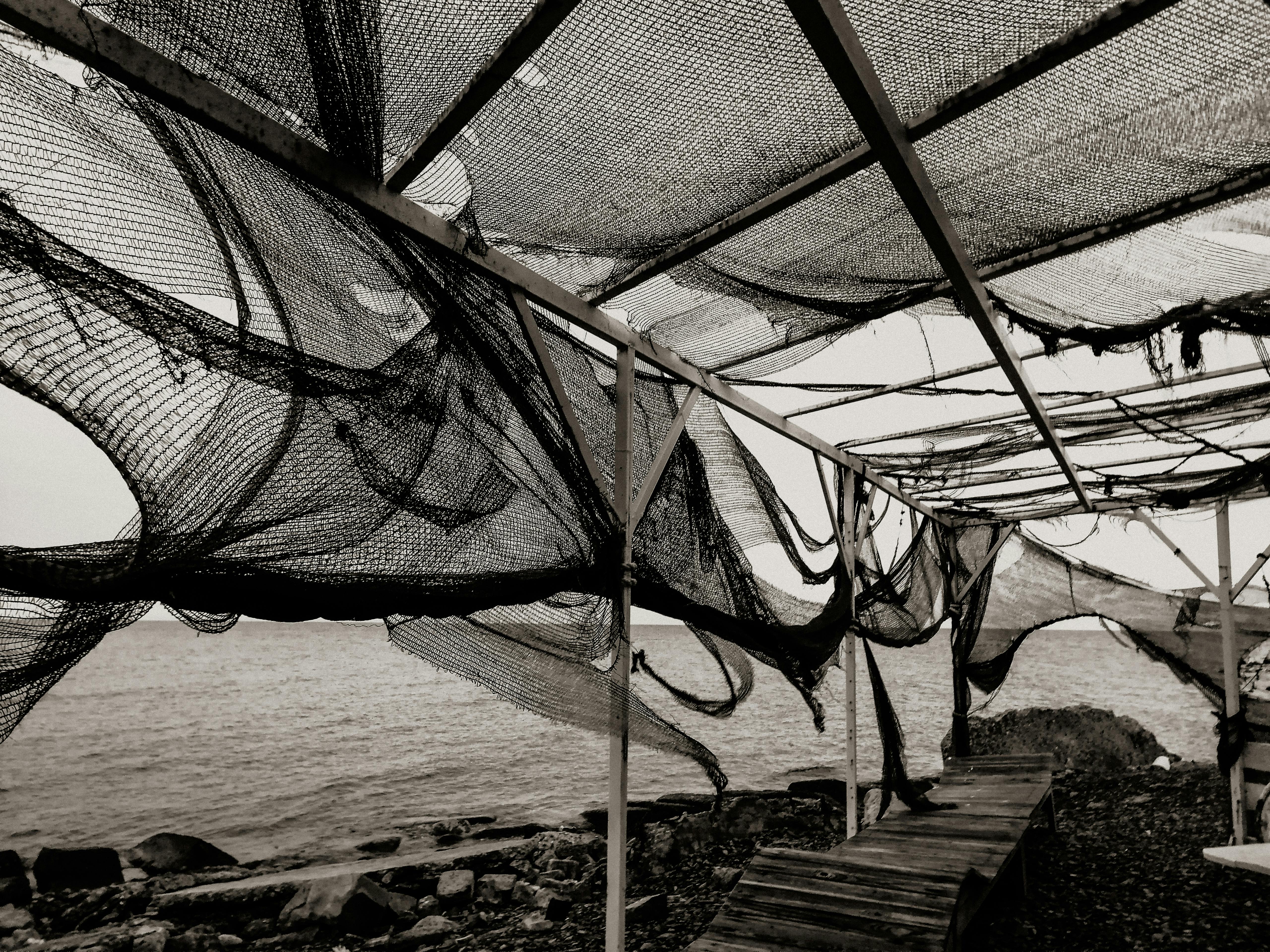 Grayscale Photo of a Broken Structure Near Sea · Free Stock Photo