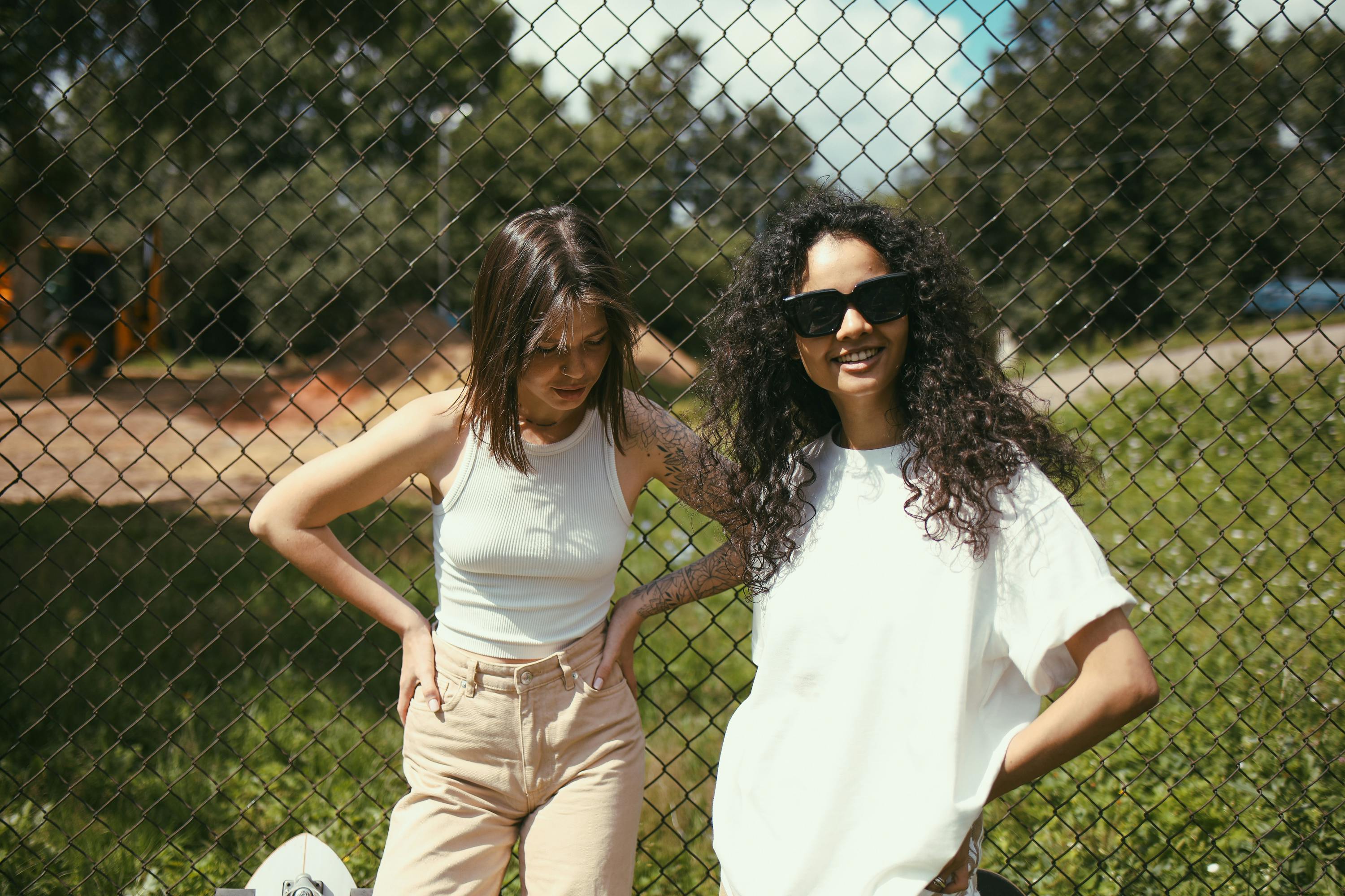 Friends Standing by the Chain Link Fence · Free Stock Photo