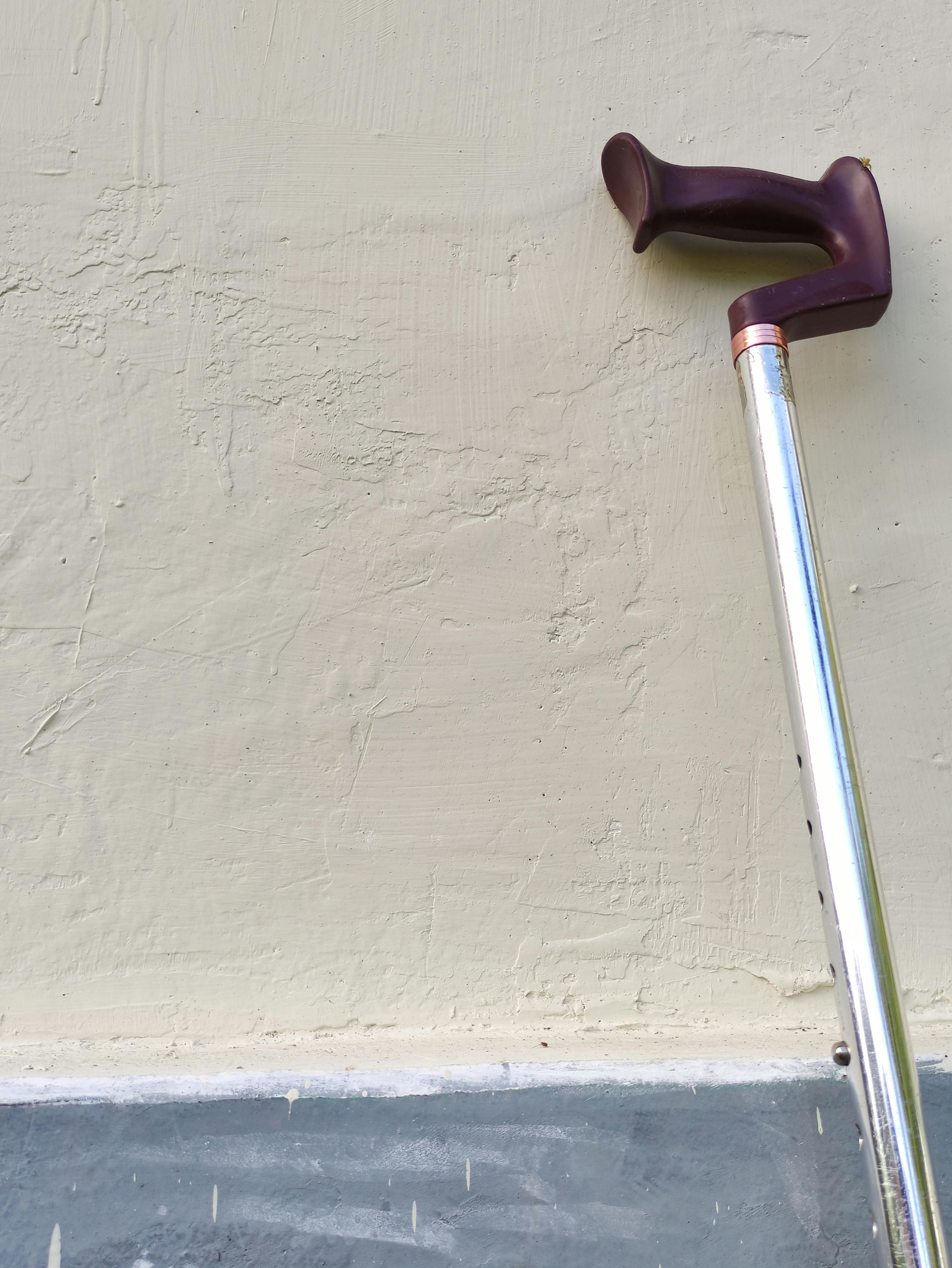 Stainless Steel Cane with Black Handle Beside the Concrete Wall · Free ...