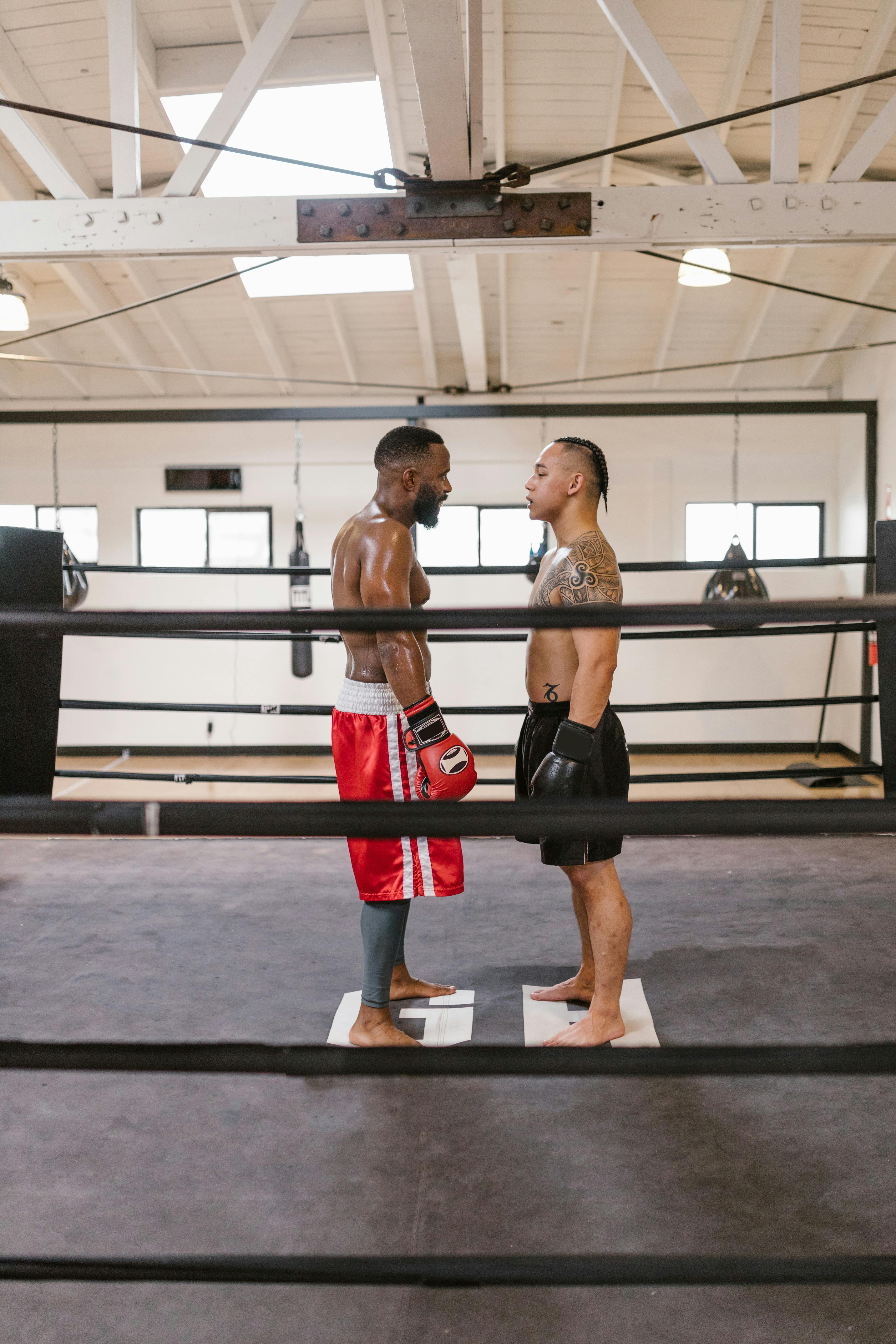 Two Shirtless Men Standing Face to Face in a Boxing Ring · Free Stock Photo