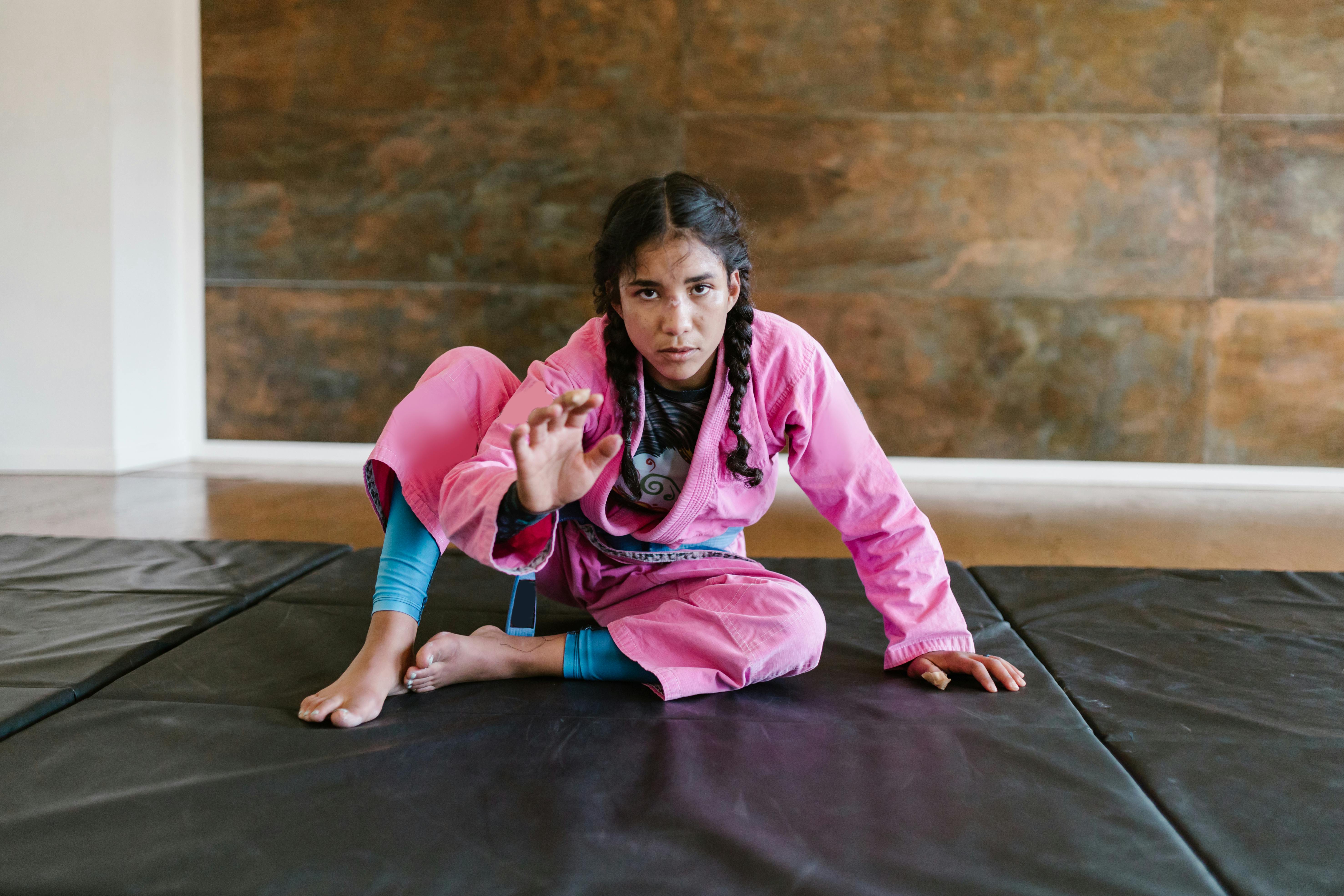 A Woman with Braided Hair Wearing a Pink Gi · Free Stock Photo