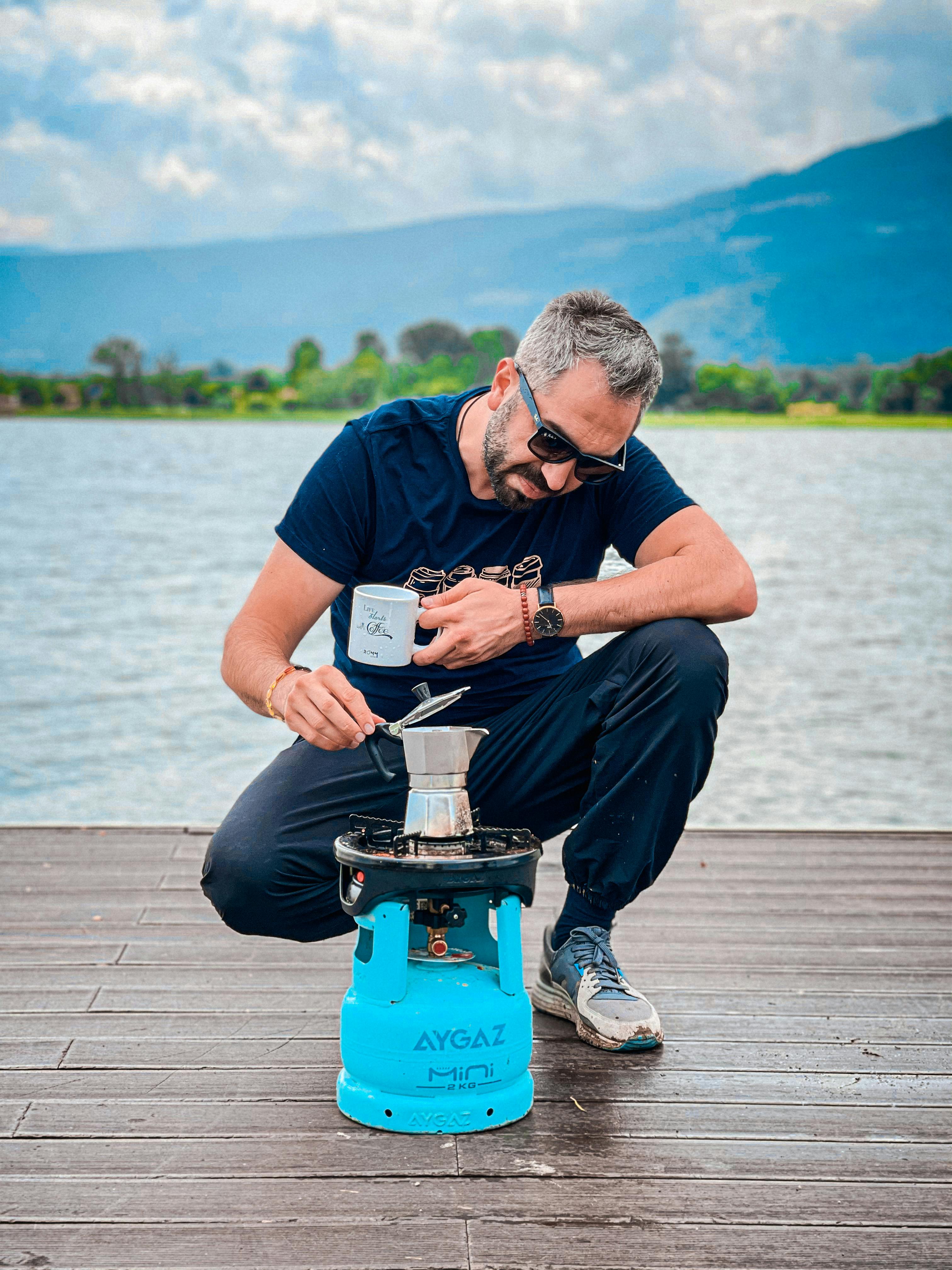 Man Boiling Water of a Portable Burner · Free Stock Photo