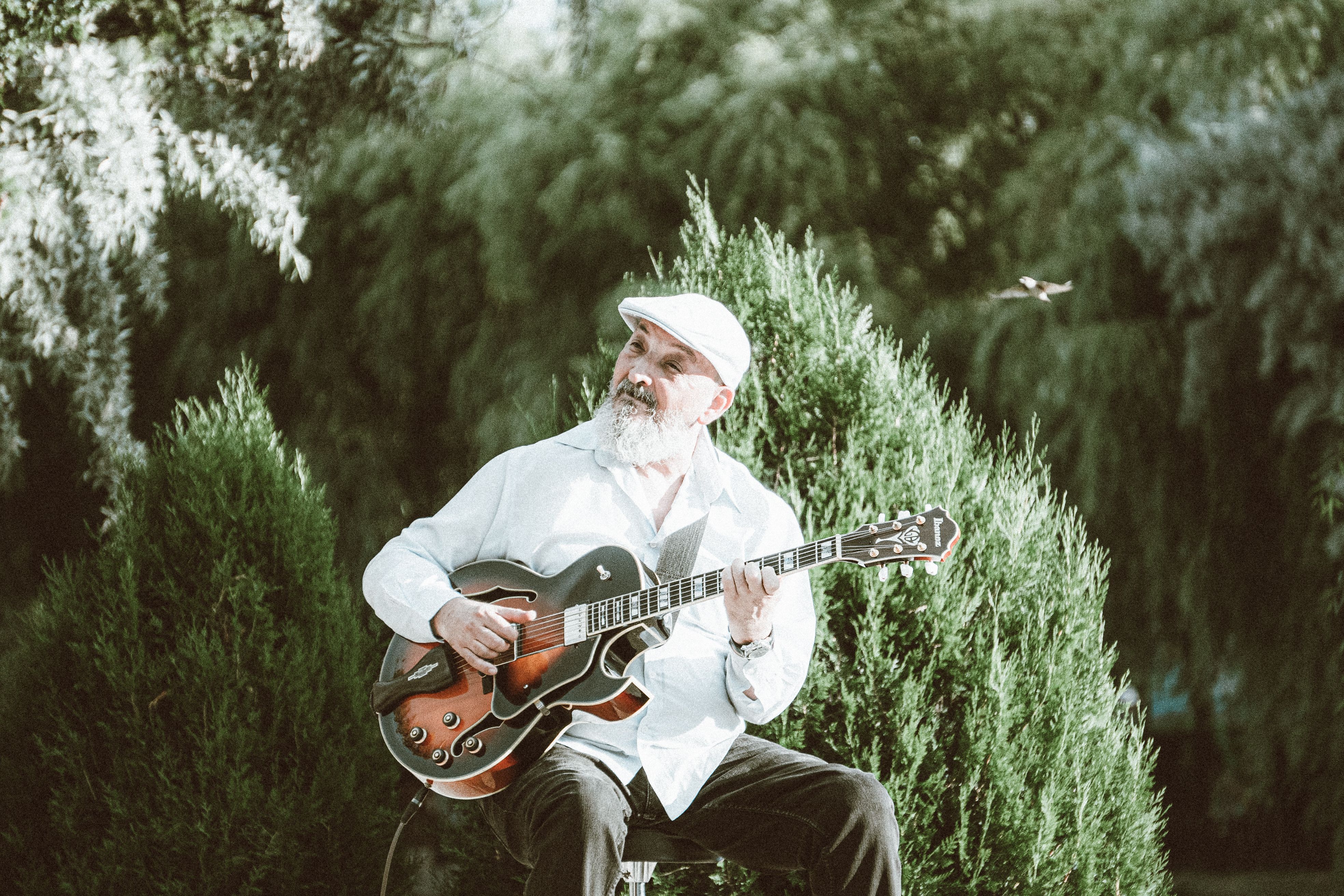 Man in Gray Tank Top Playing Black and White Stratocaster Electric ...