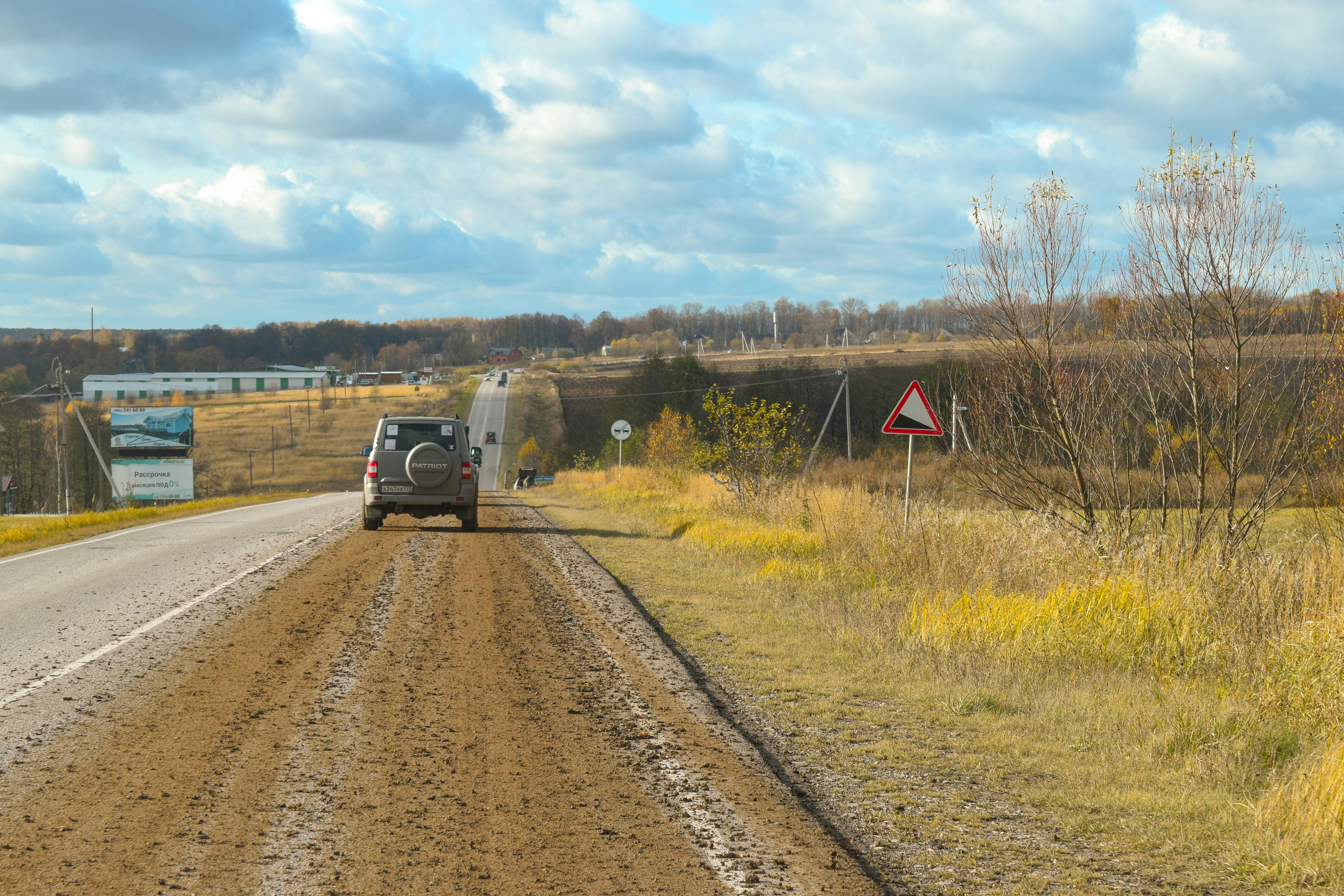 Car Driving on a Road with Dirt · Free Stock Photo