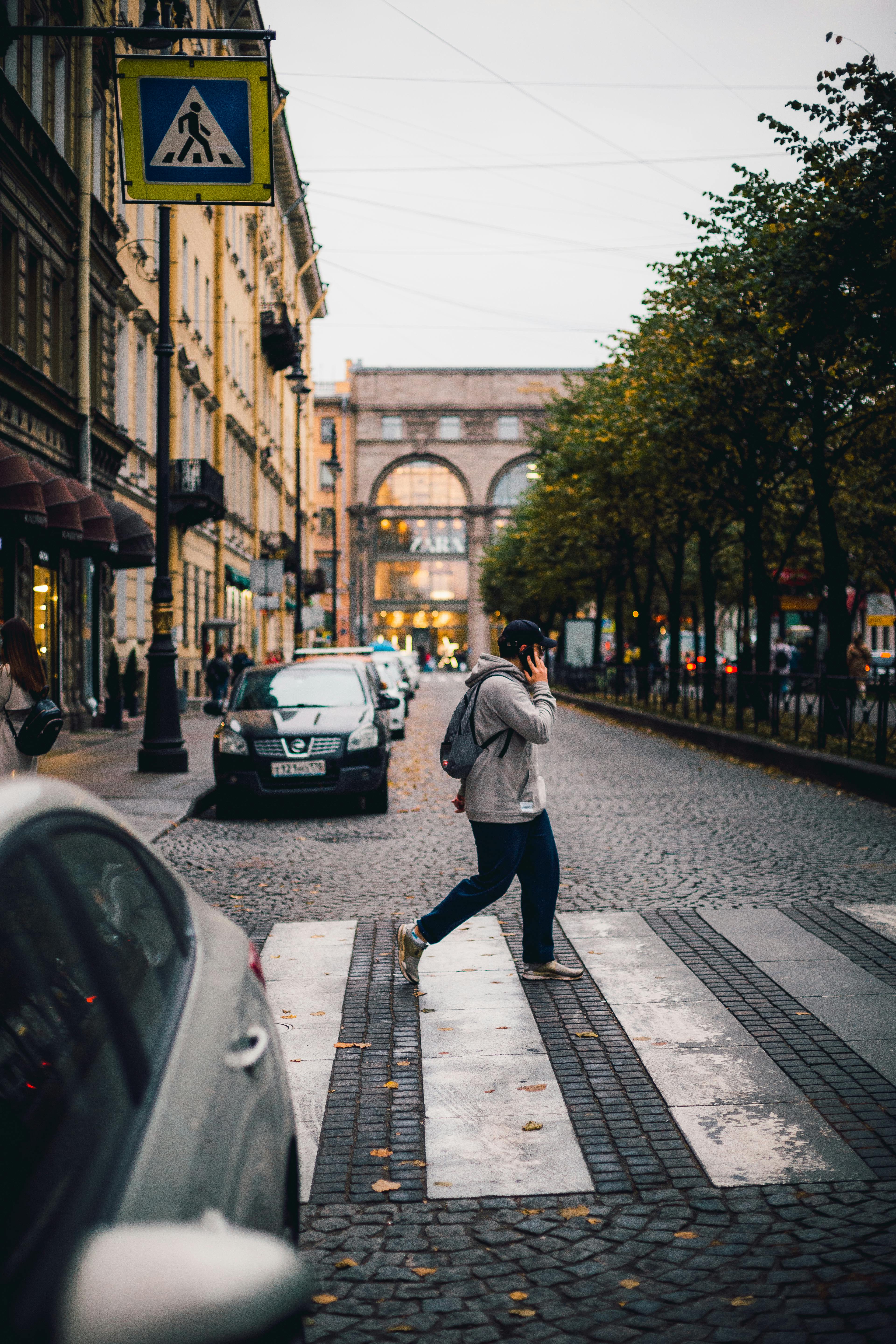 Photo Of Person Walking On Pedestrian Lane · Free Stock Photo