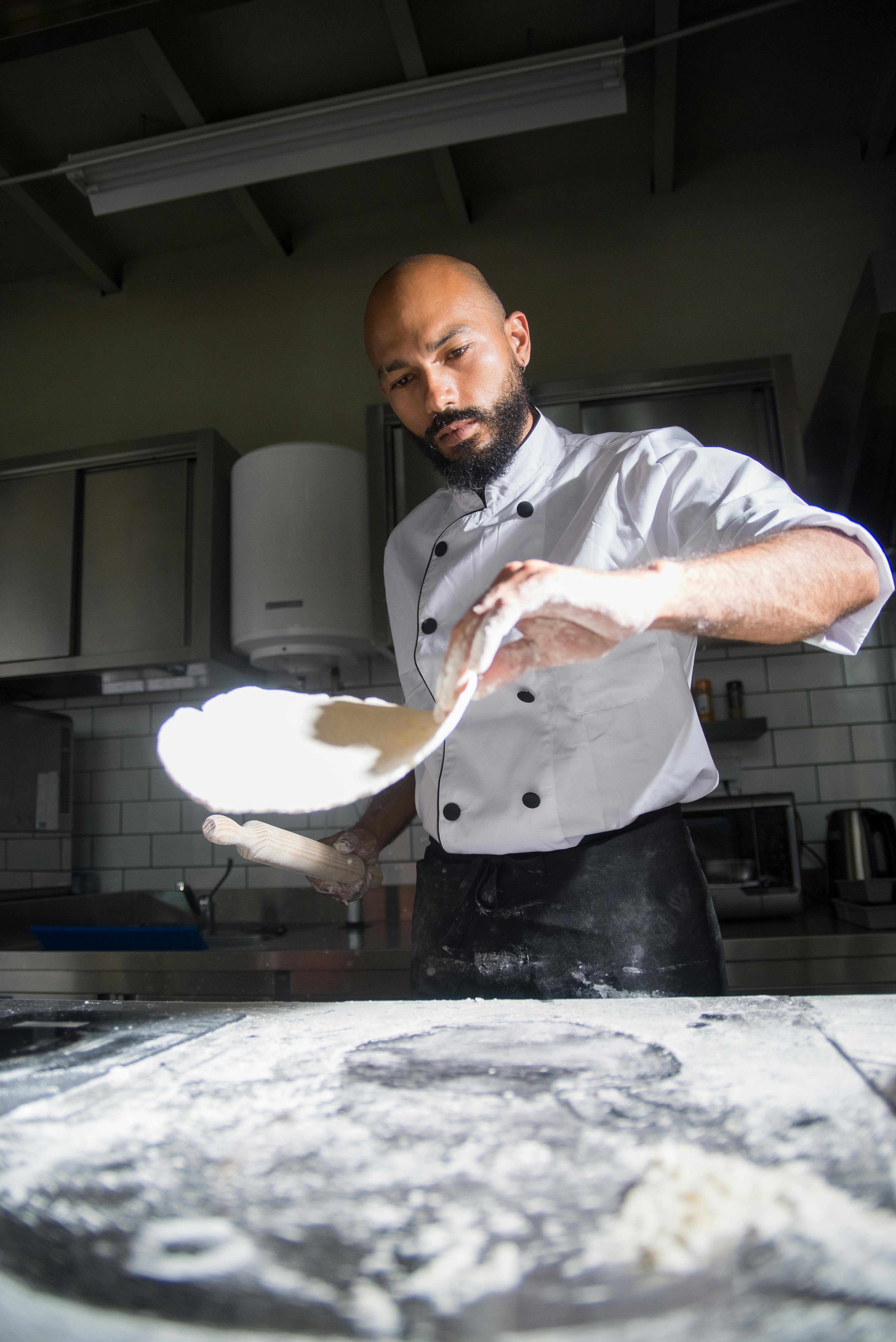A Man in White Chef Uniform Cooking in the Kitchen · Free Stock Photo