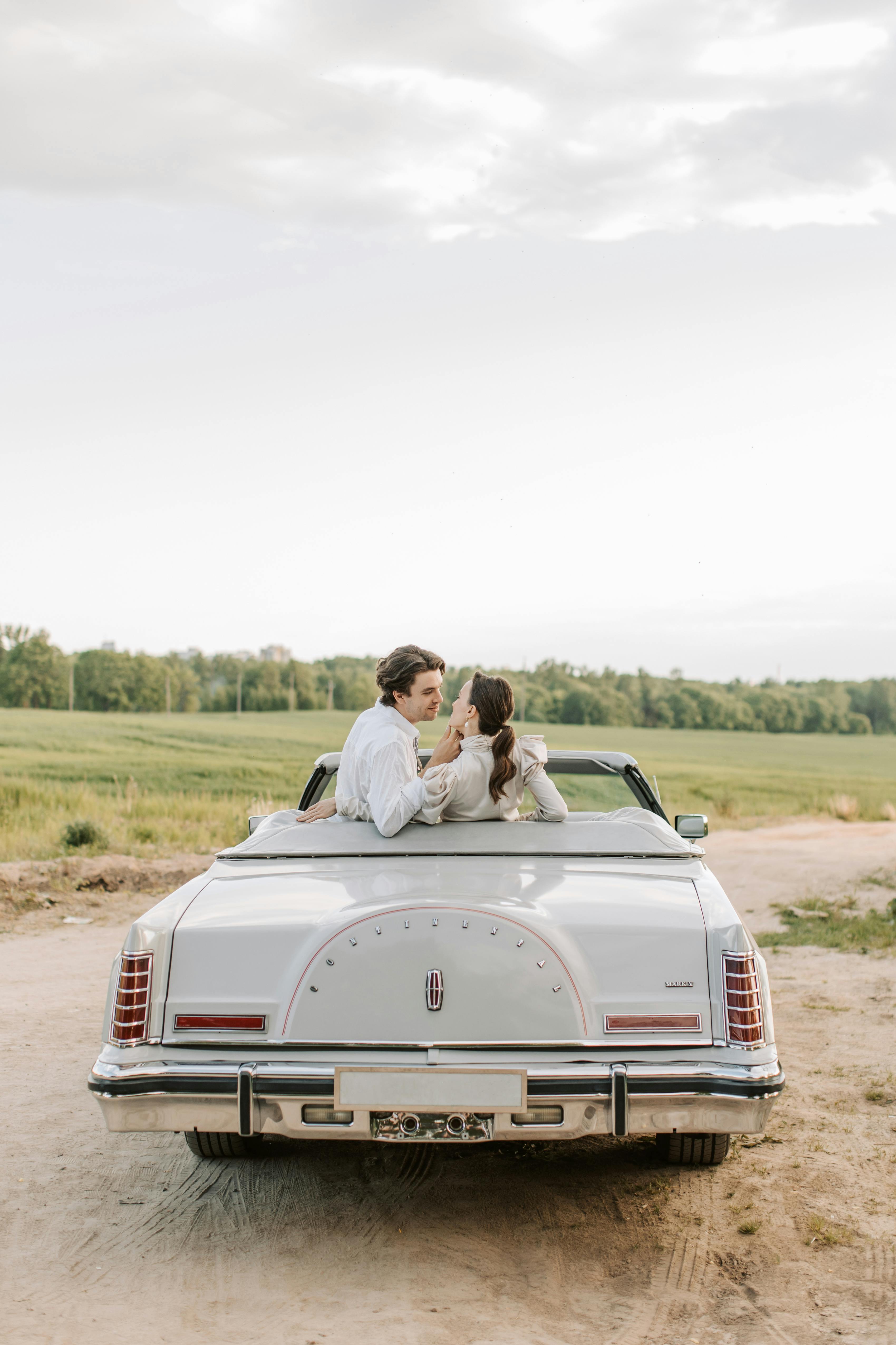 A Romantic Couple Kissing on the Car · Free Stock Photo