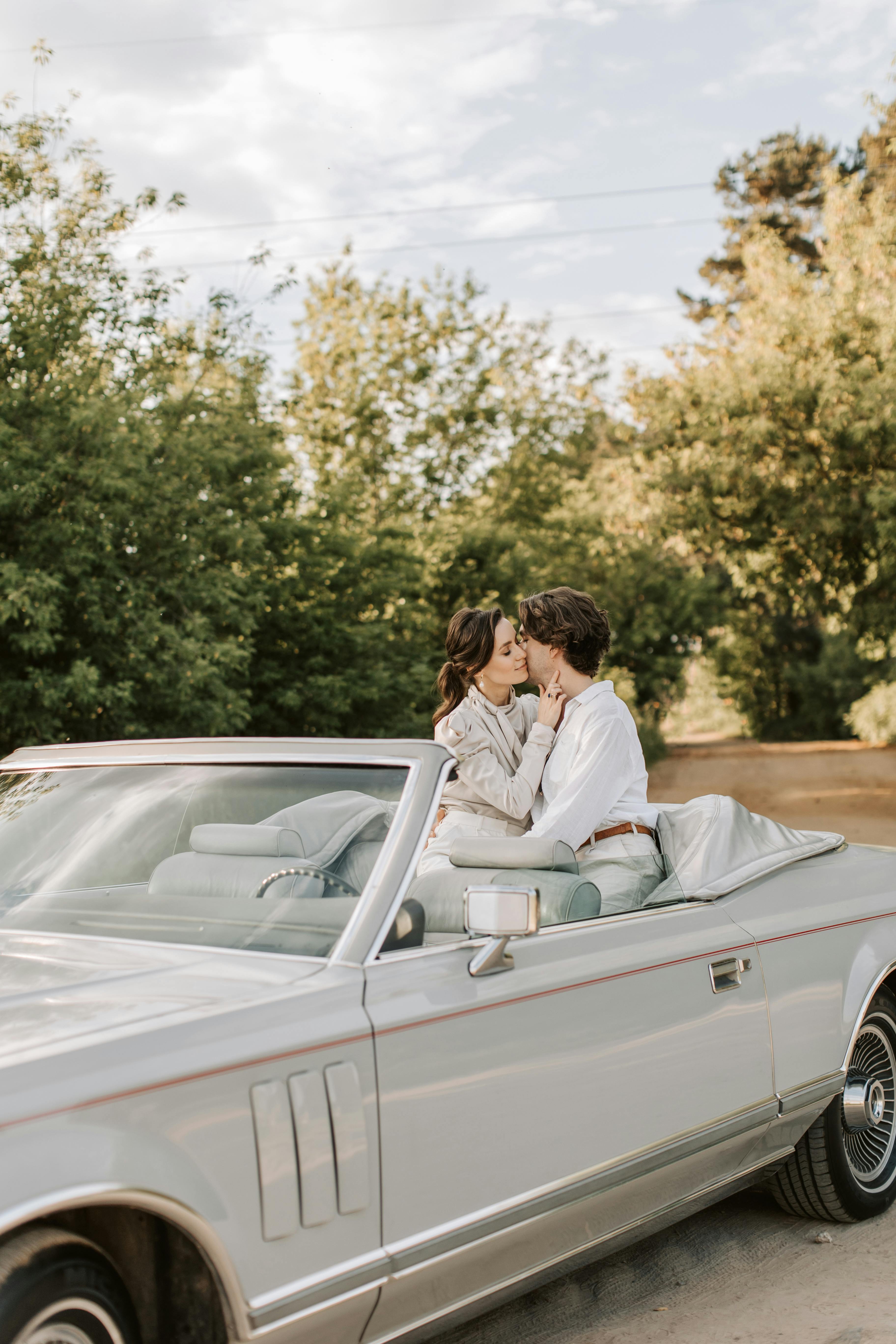 A Romantic Couple Kissing on the Car · Free Stock Photo