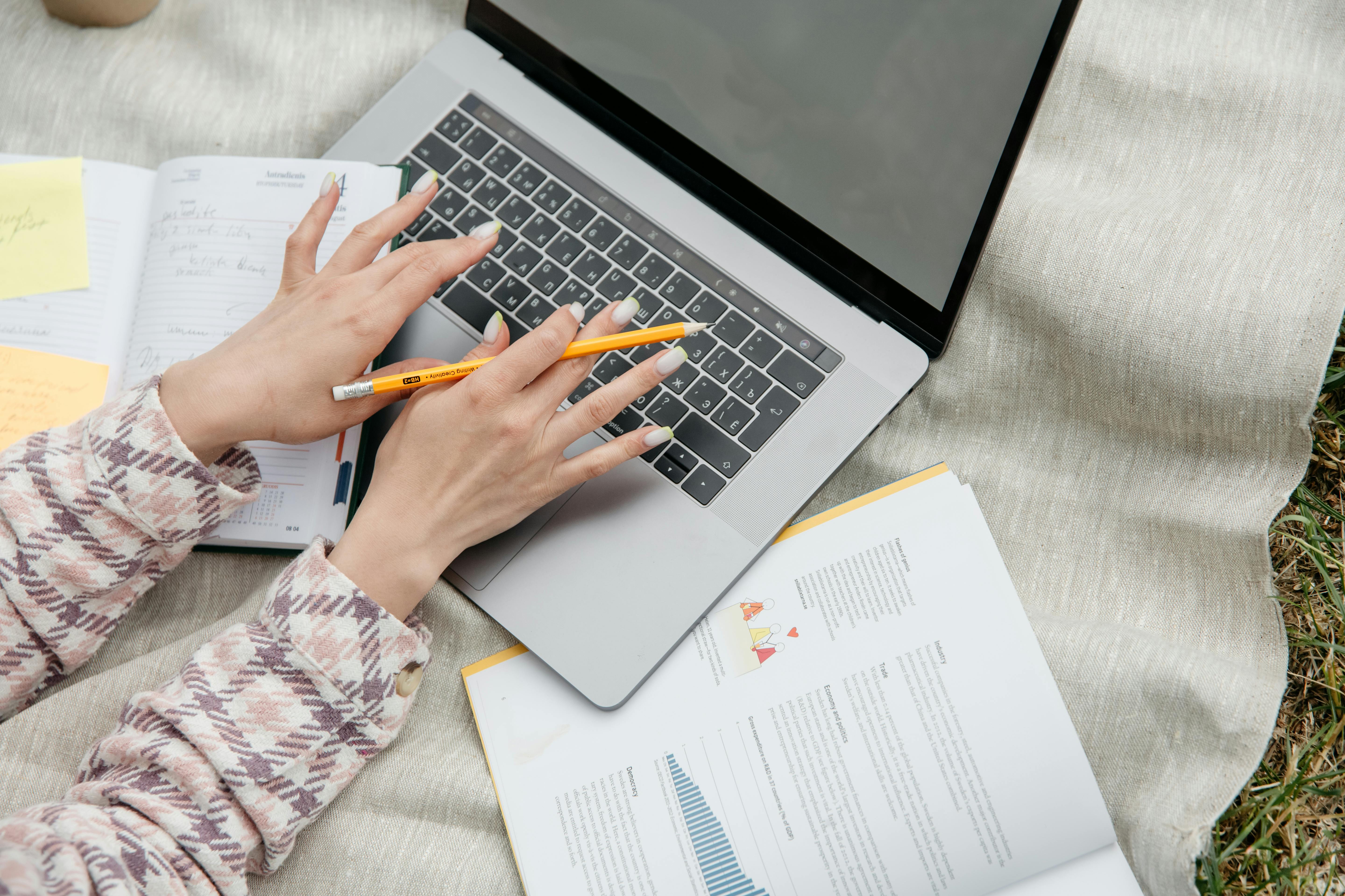 Overhead Shot of a Person with a Pencil Typing on a Laptop · Free Stock ...