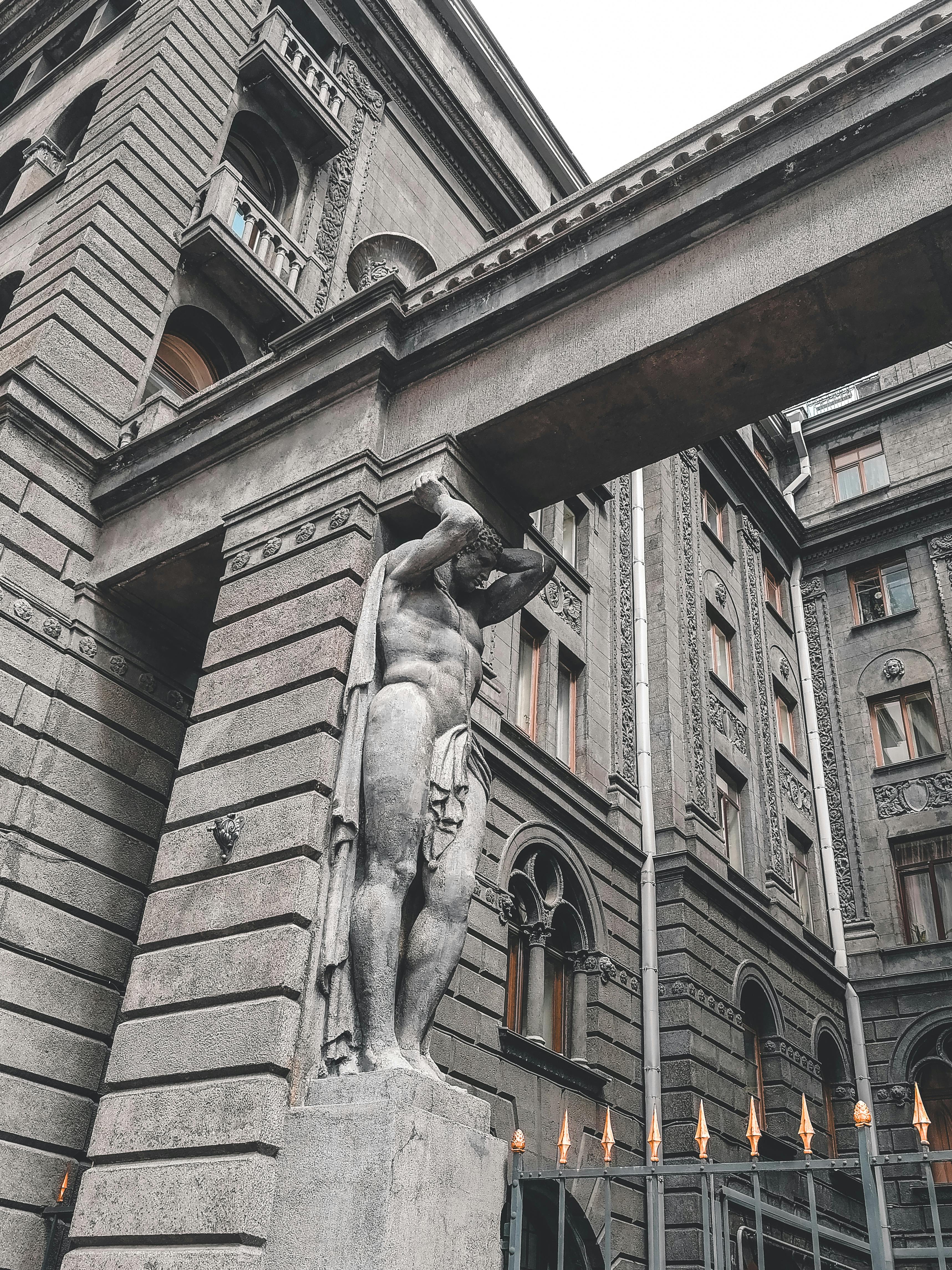 Sculpture by Gate to Building · Free Stock Photo