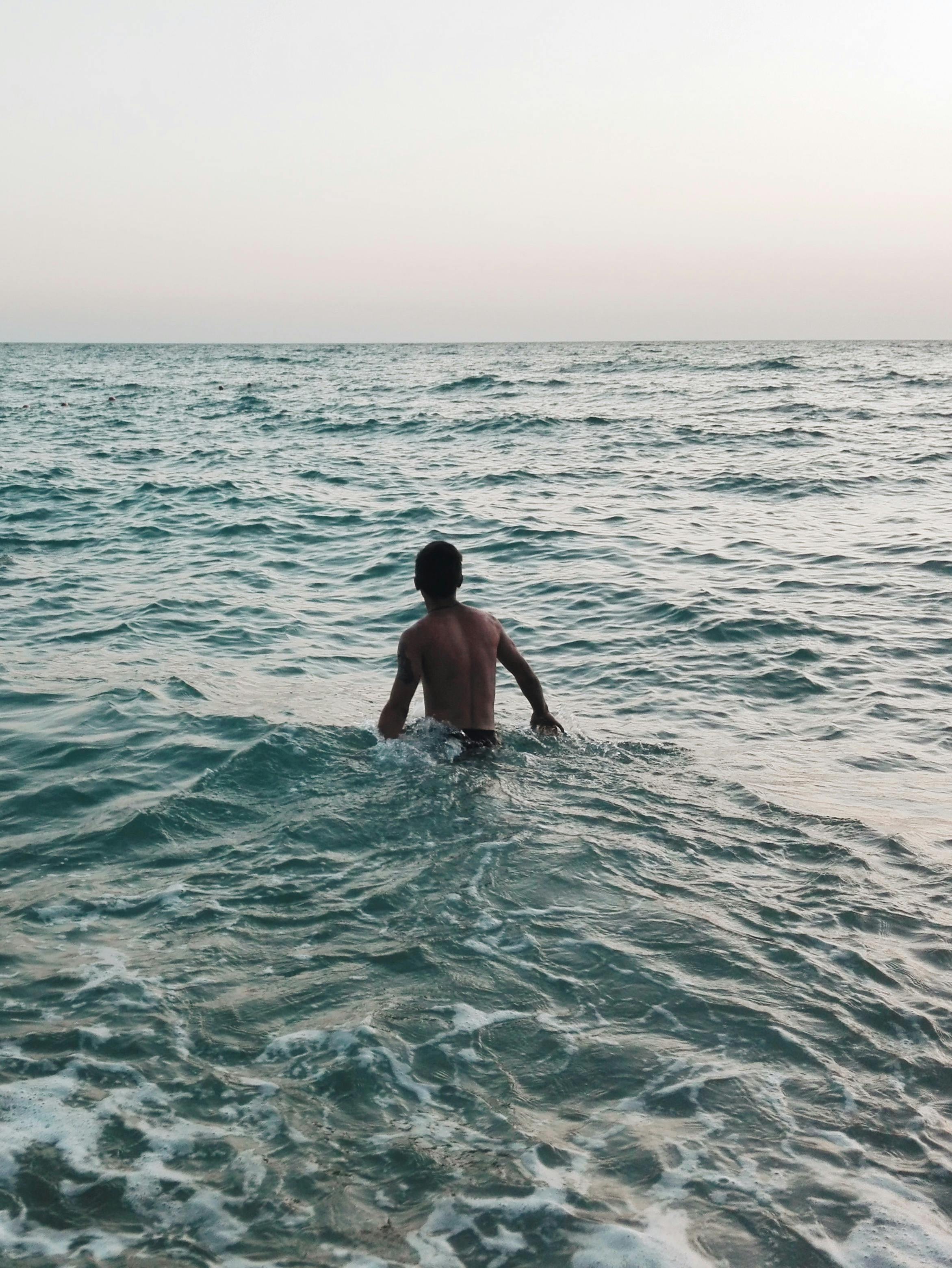 Person in Water on Seashore · Free Stock Photo