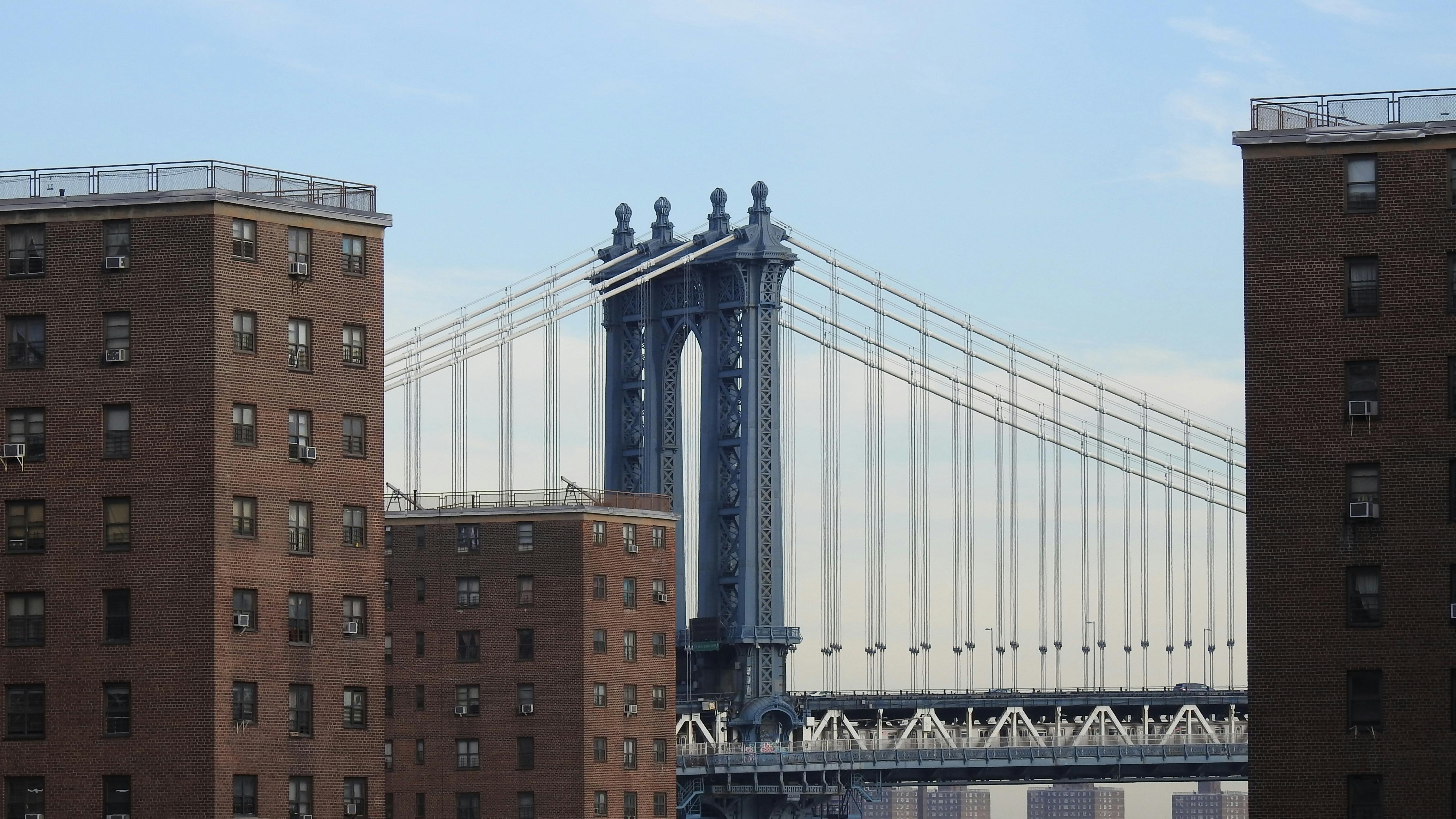 Brown Concrete Building Near Bridge Under Blue Sky · Free Stock Photo