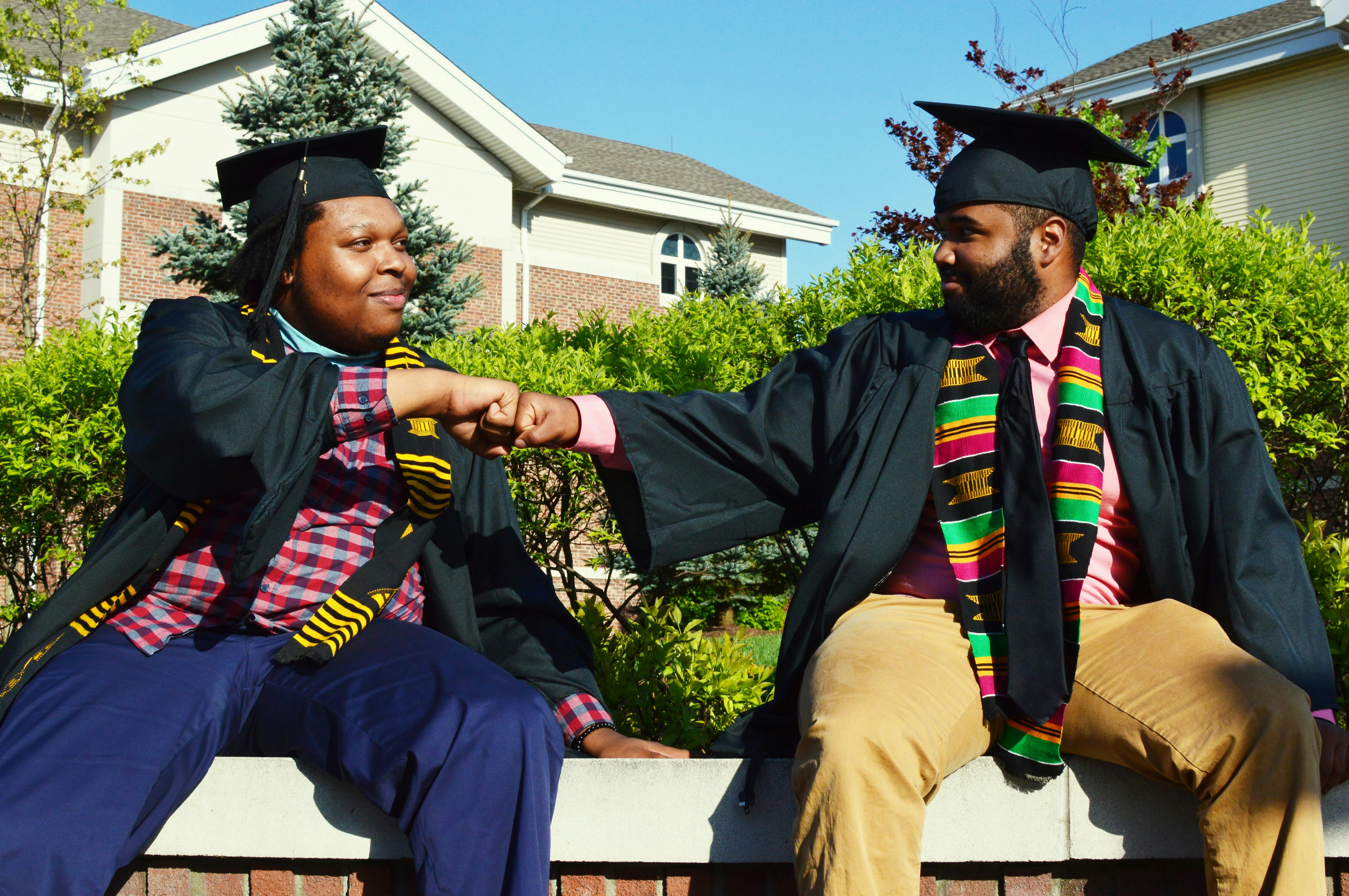 Two Men in Black Graduation Gowns Sitting on a Concrete Bench · Free ...