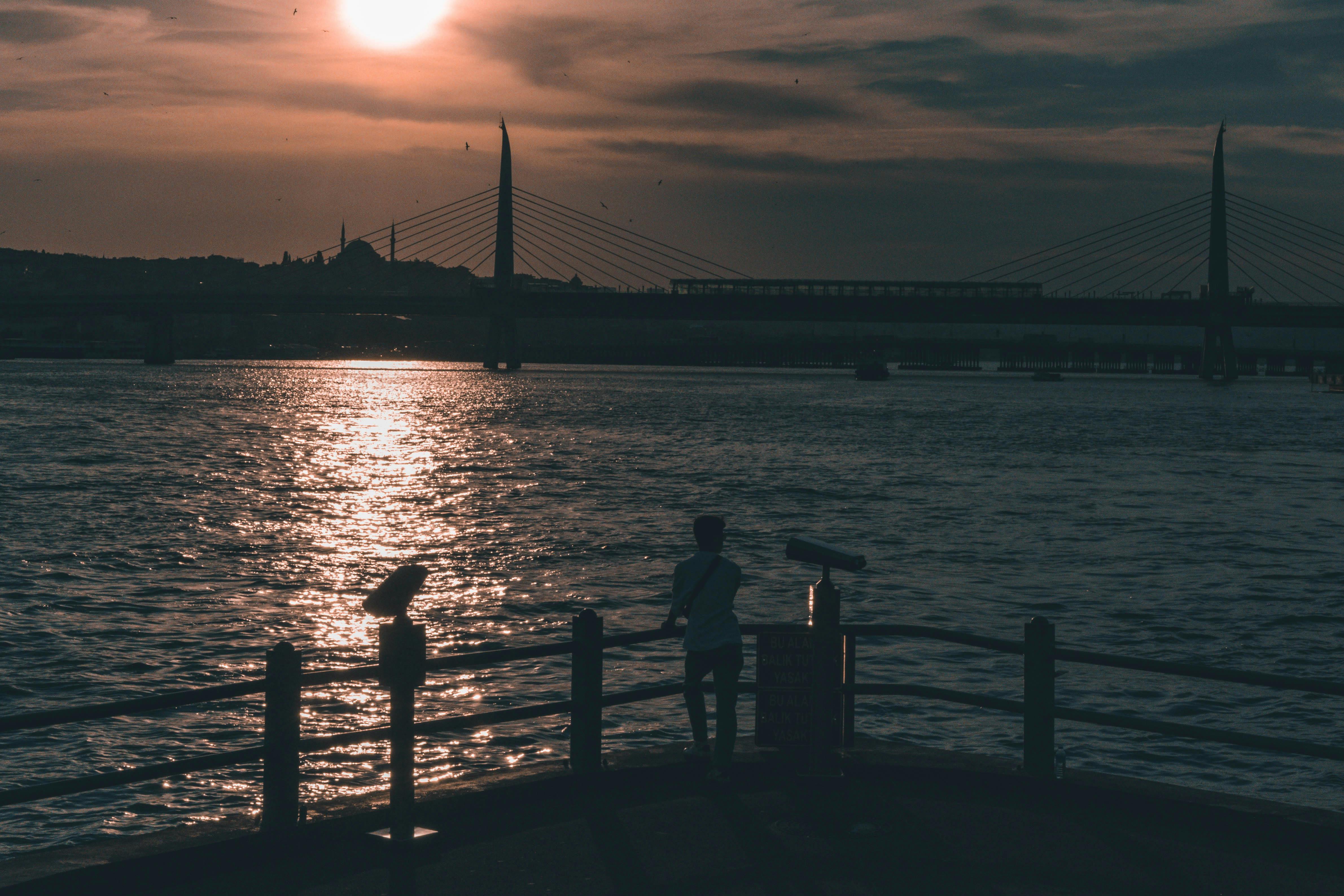Person Standing on Bridge on Sunset · Free Stock Photo