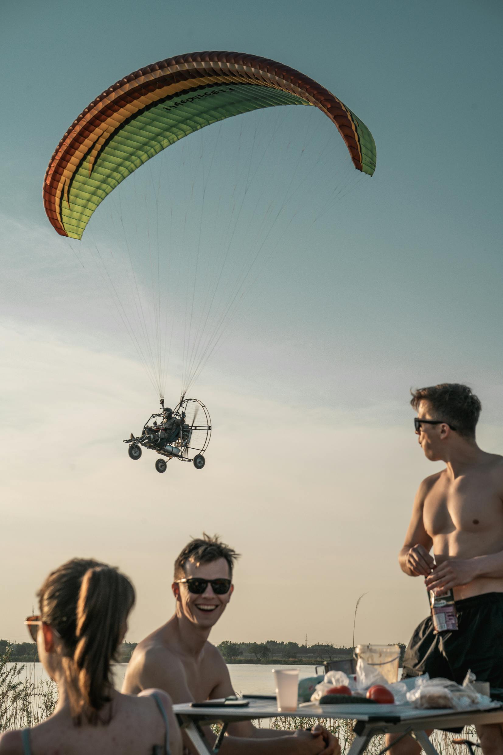 Person Flying on a Powered Paraglider and Young People Having Fun on ...