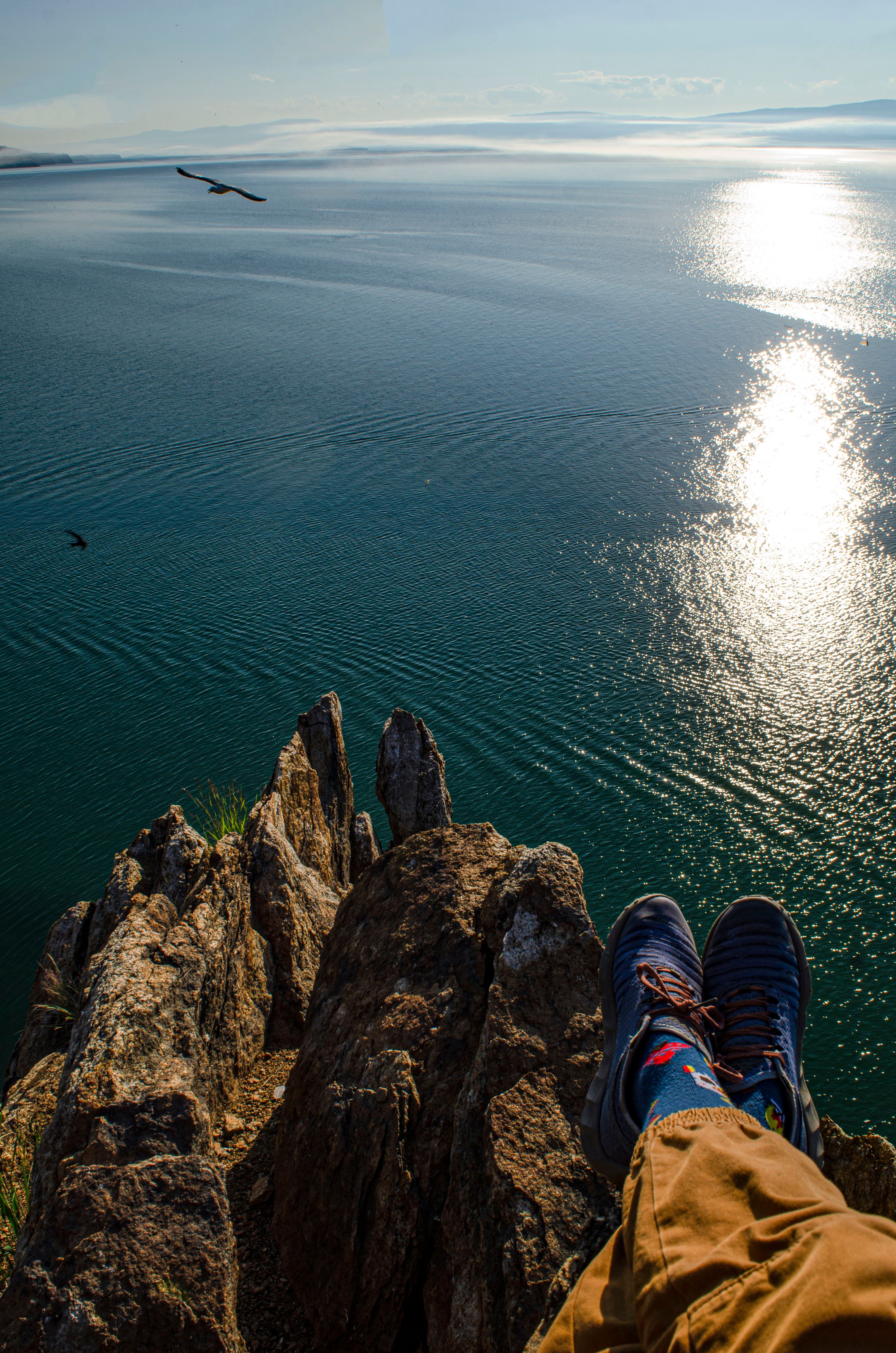 A Person Sitting on a Cliff with a View of the Beautiful Ocean · Free ...