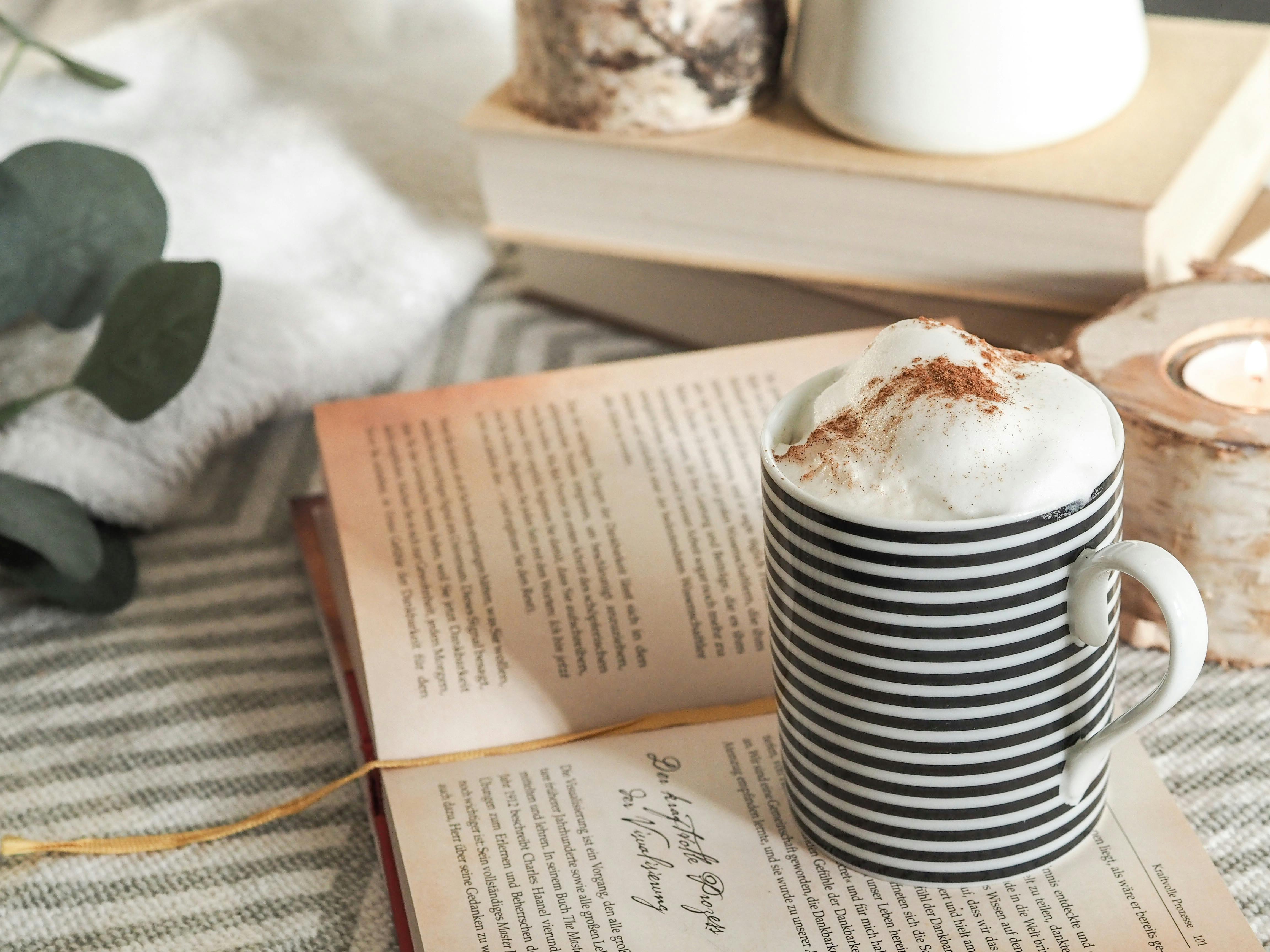 A Mug of Coffee on the Open Book · Free Stock Photo