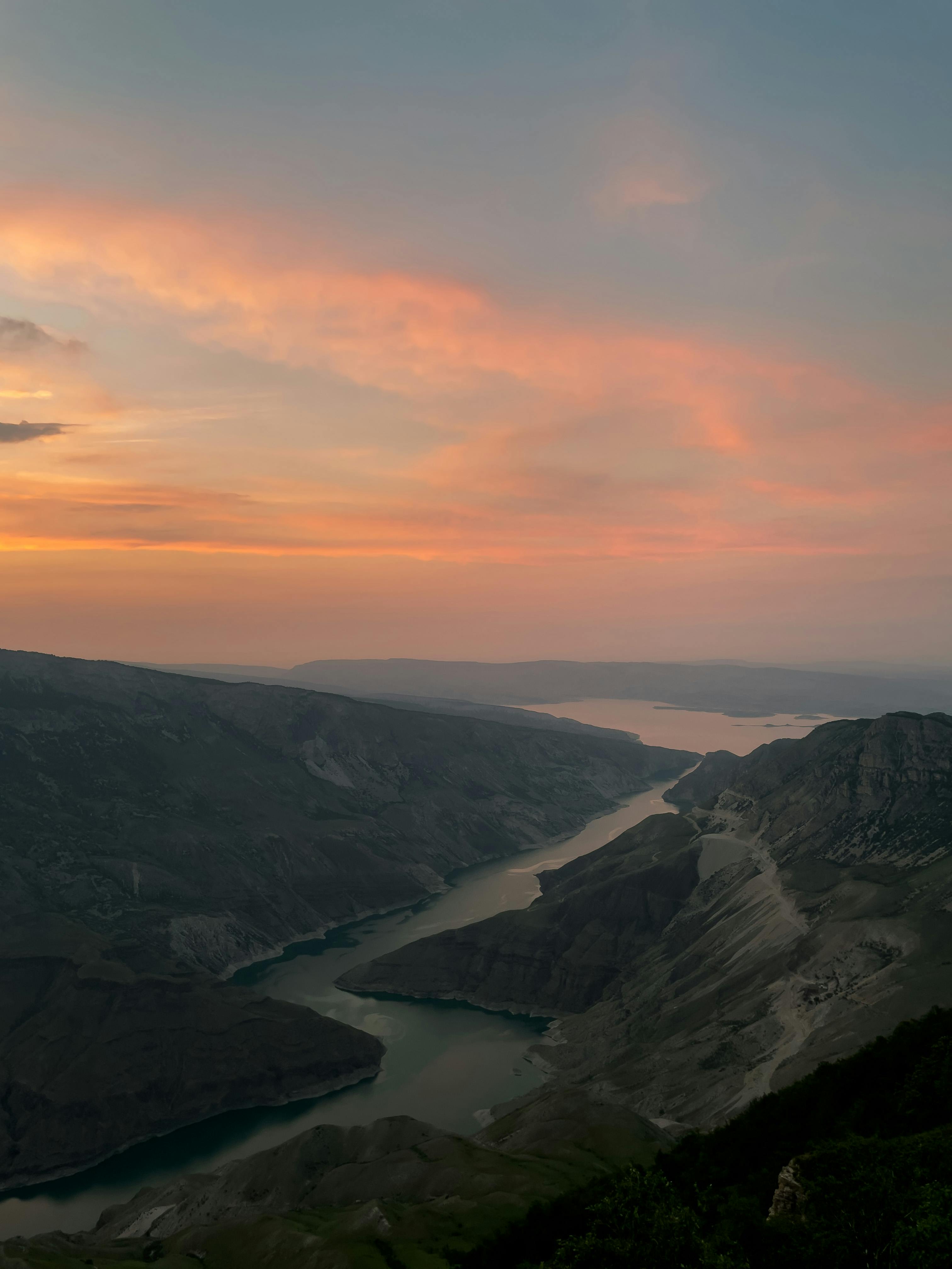 A Green Grass Field Between Mountains · Free Stock Photo