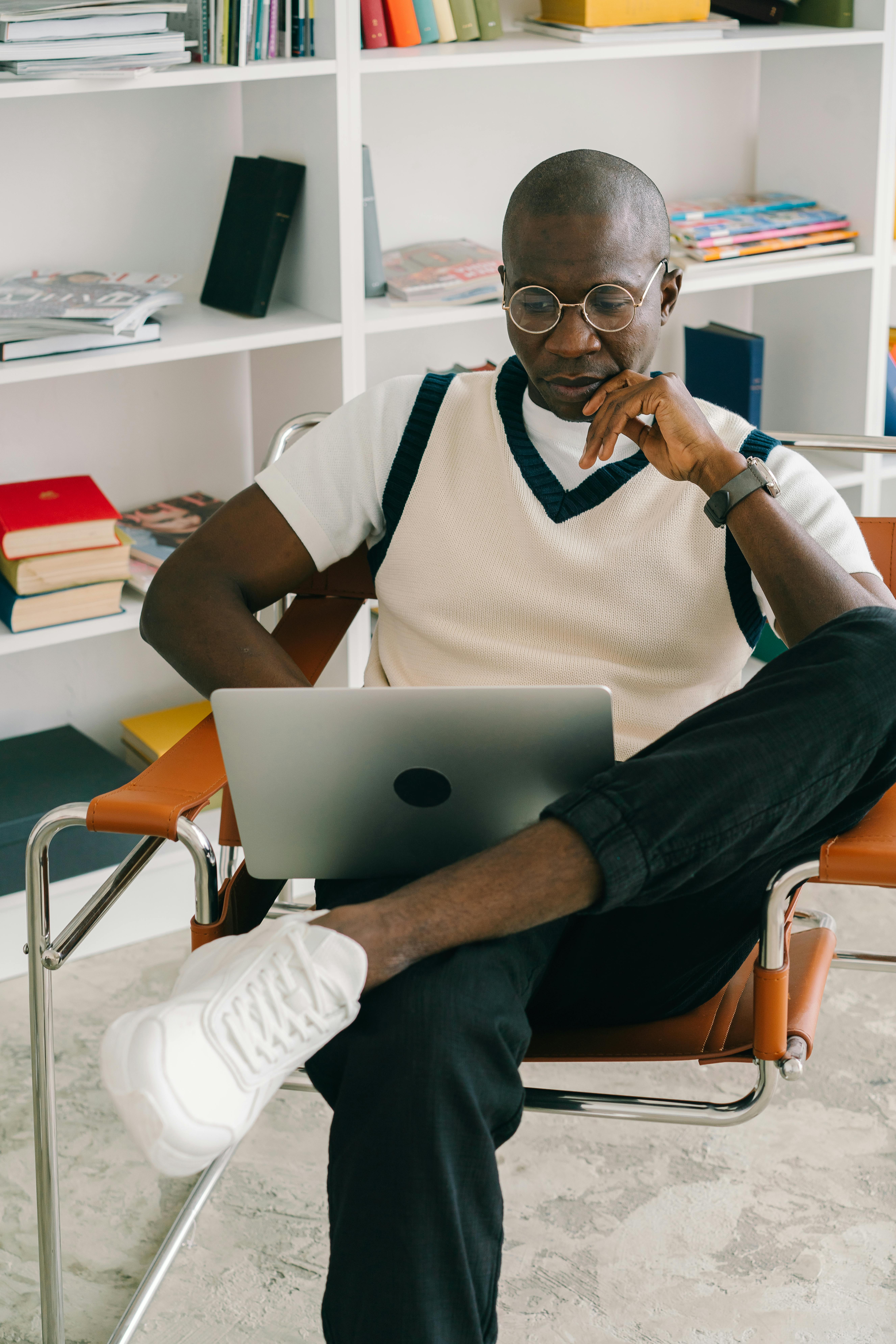 Man Standing while Using a Silver Laptop · Free Stock Photo