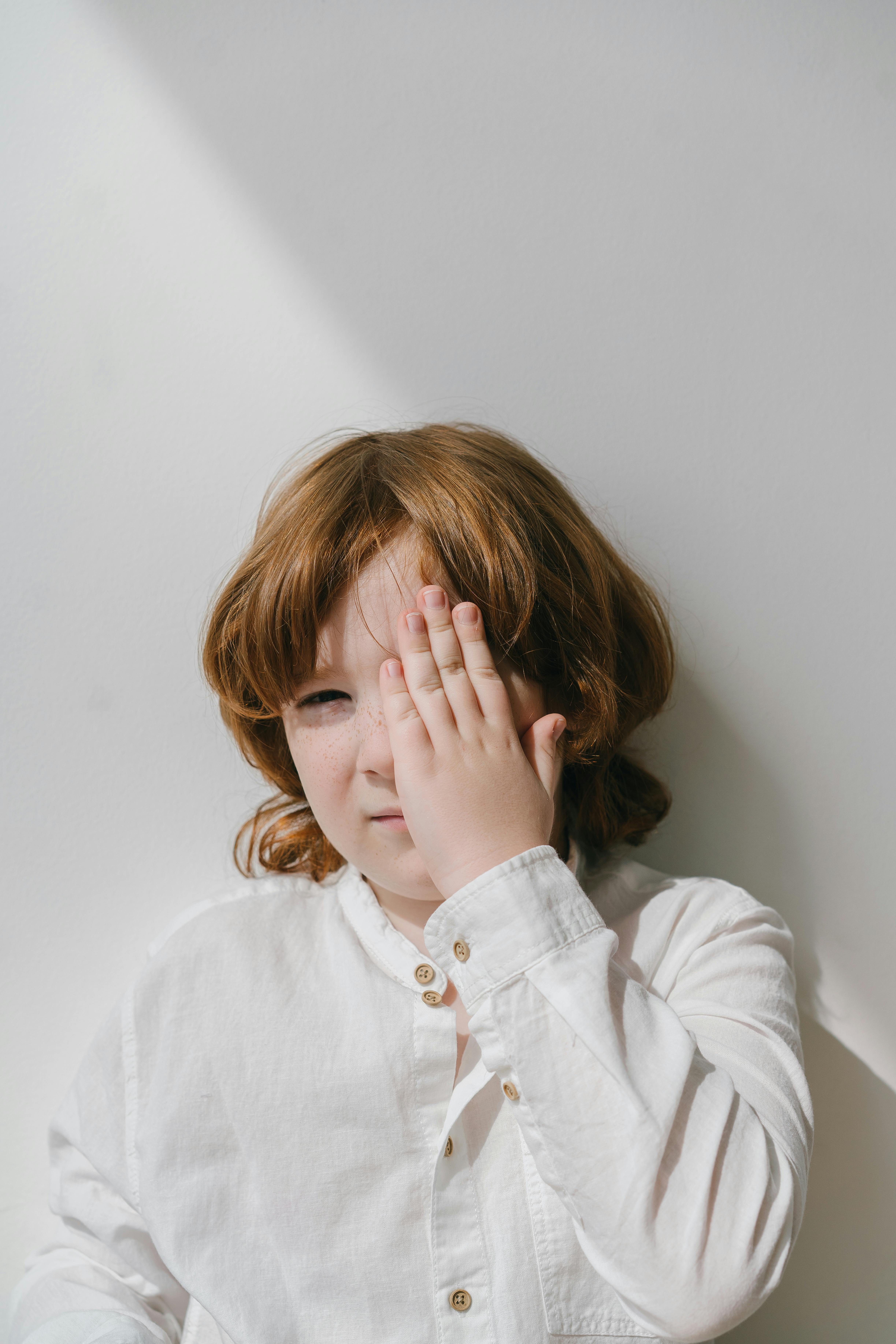A Boy Covering His Face With His Hand · Free Stock Photo