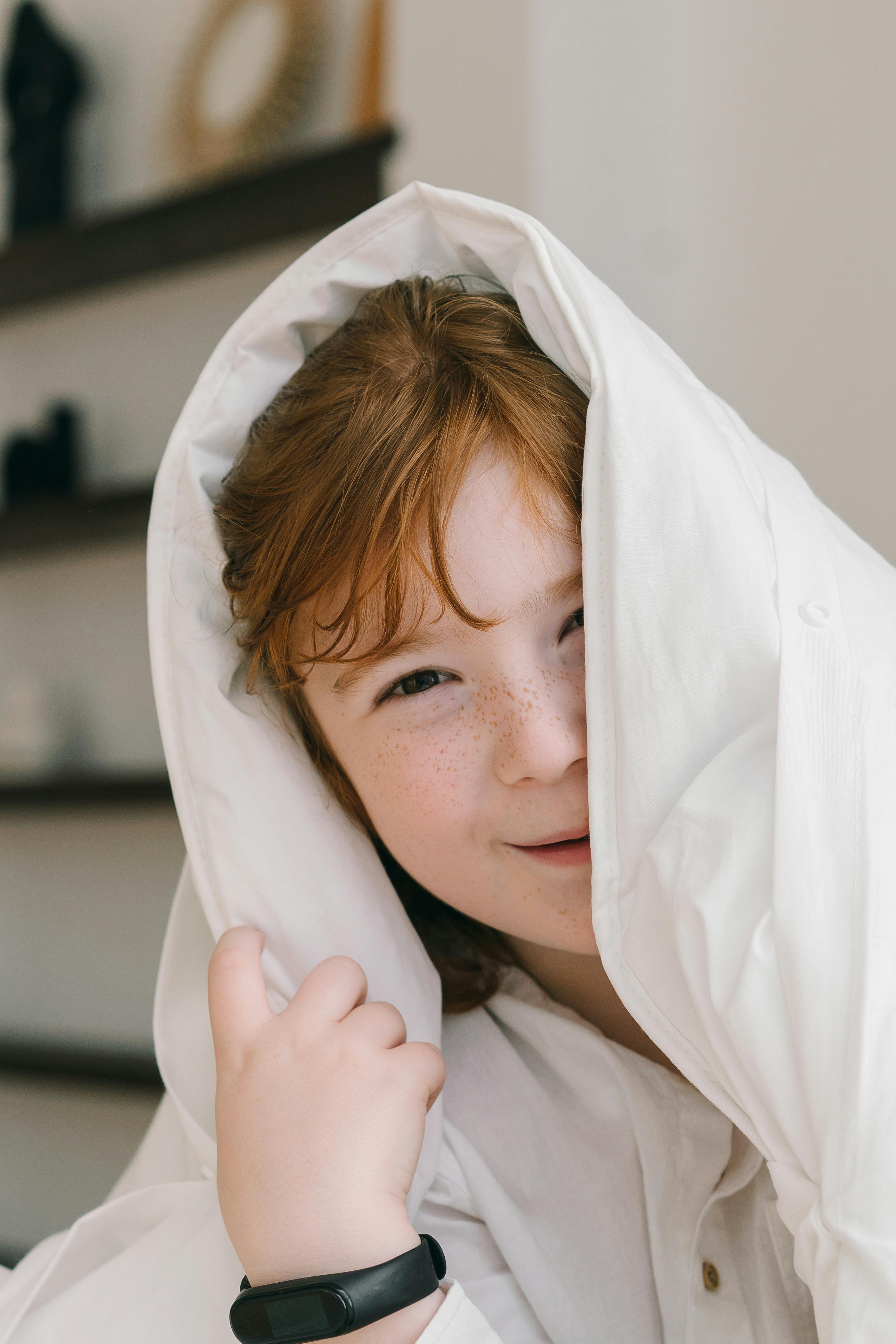 Close-Up Shot of a Boy Covering His Face With a Blanket · Free Stock Photo