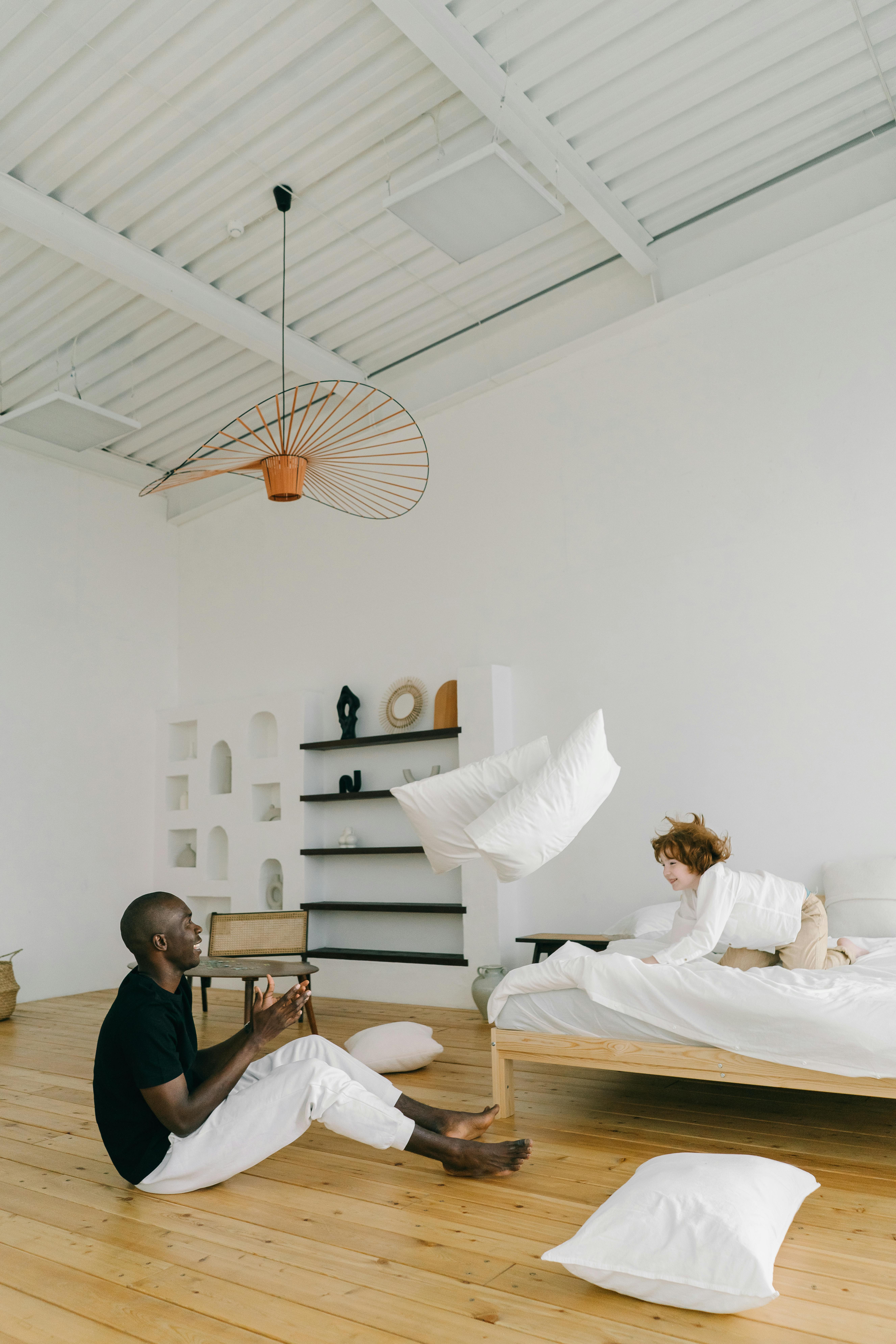 Man and Little Boy Throwing Pillows · Free Stock Photo
