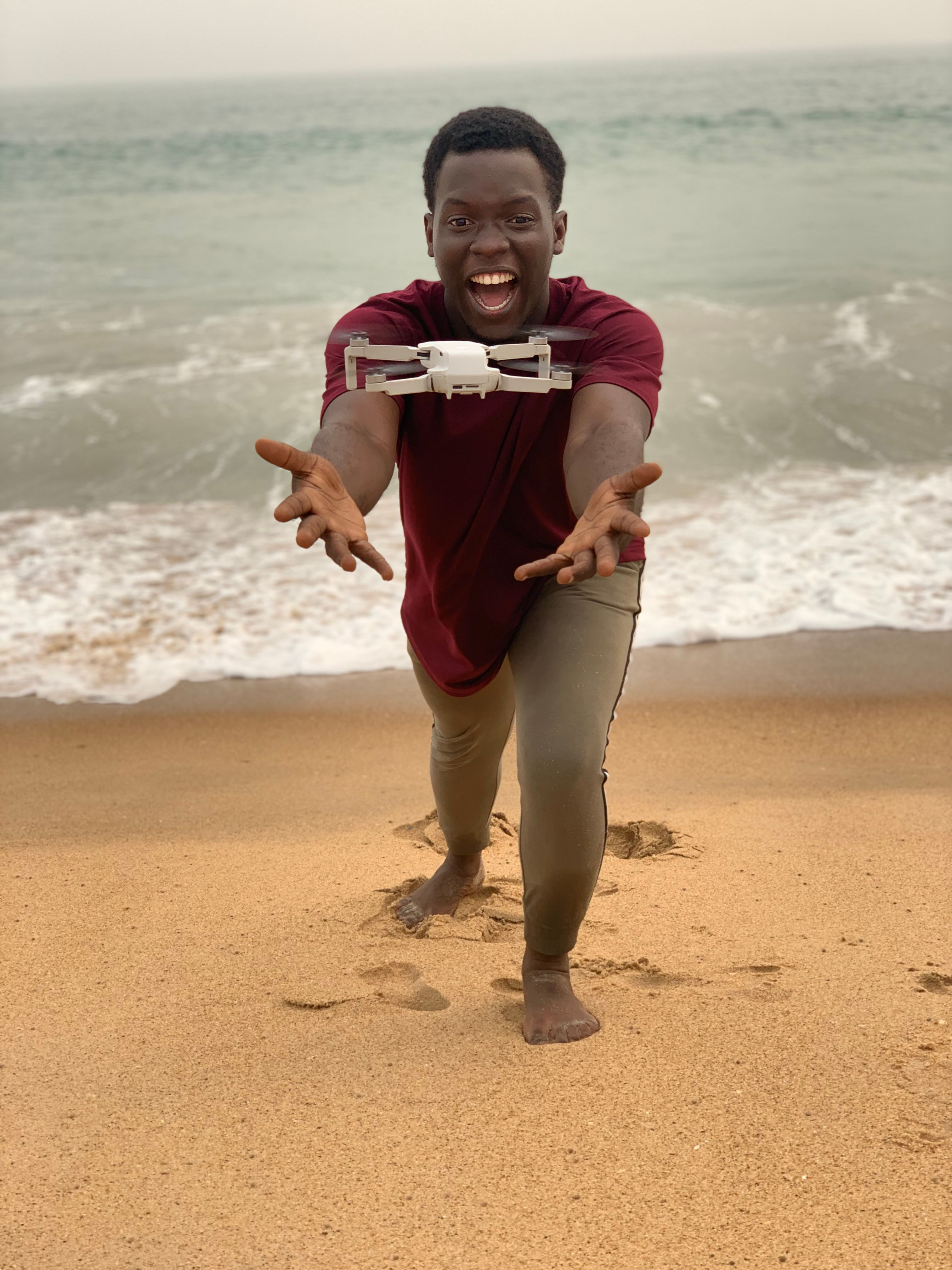 Man in the Beach Catching the Flying Drone · Free Stock Photo