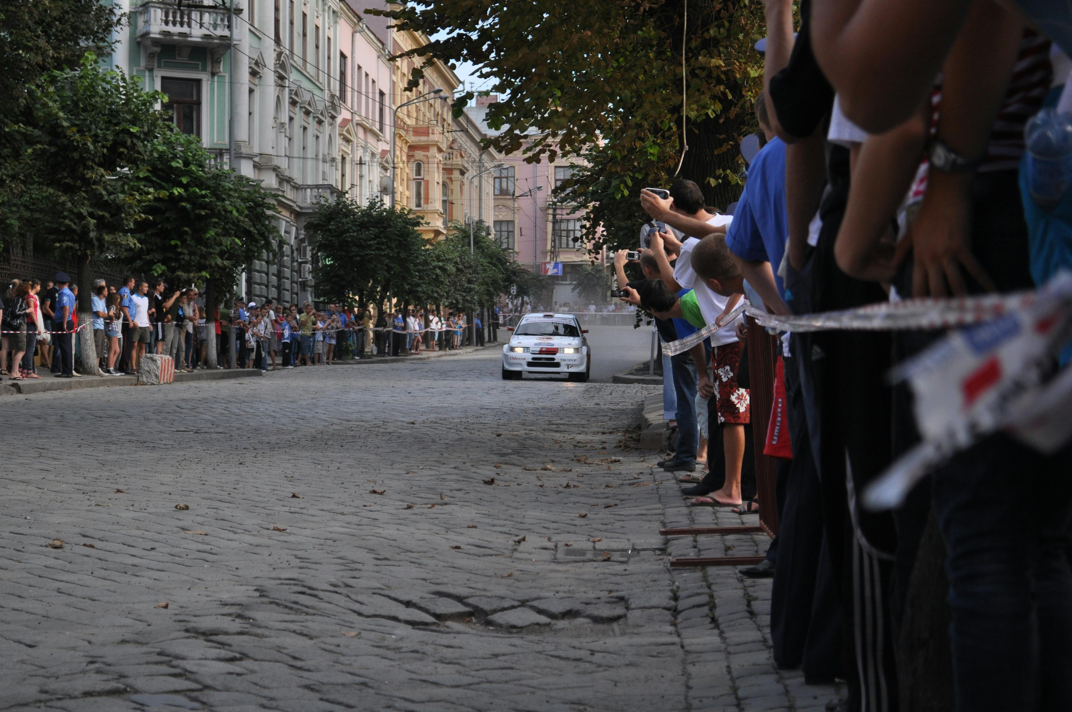 Crowd at the Side of a Road Looking at the White Car · Free Stock Photo