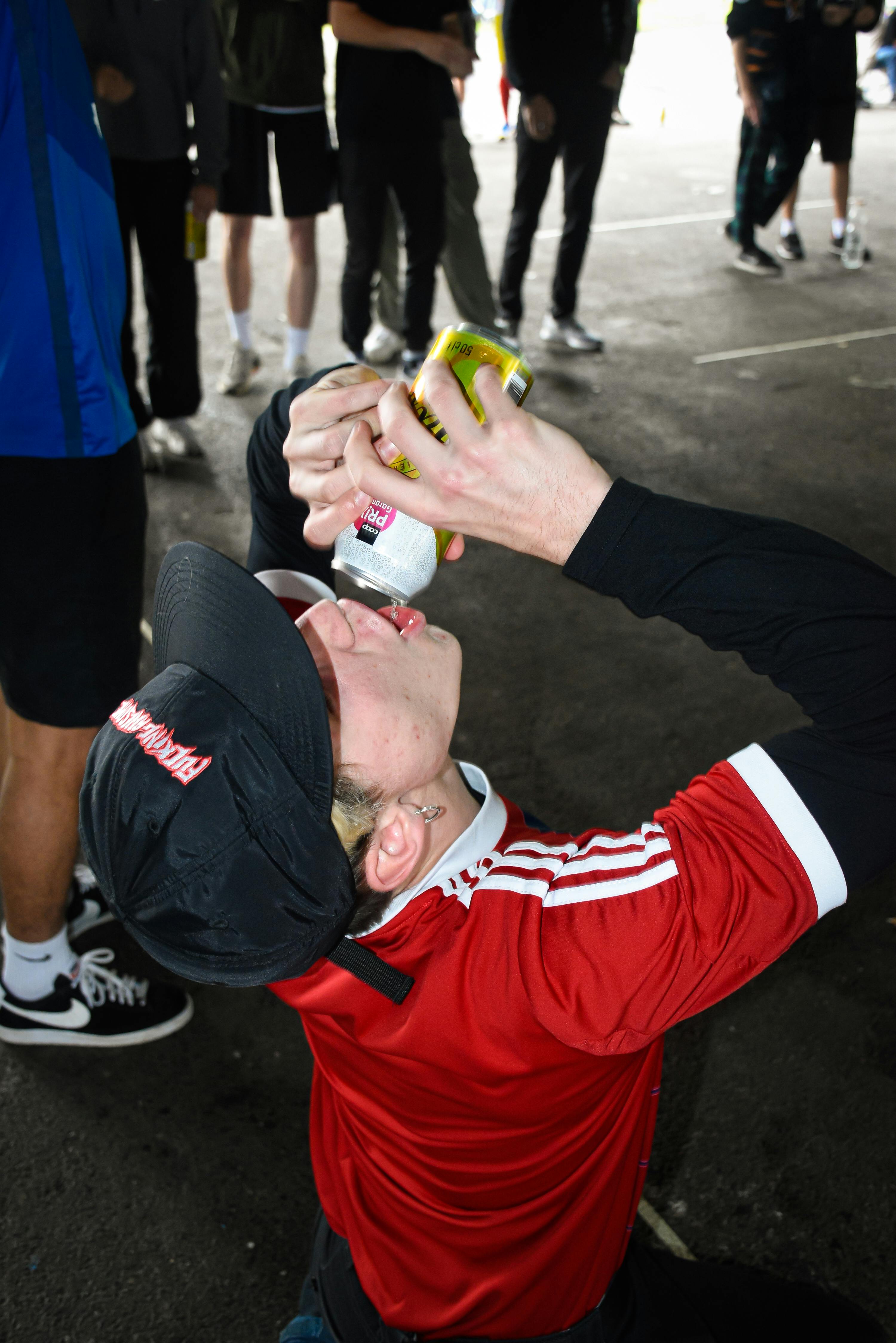 Man in Red Shirt chugging Beverage · Free Stock Photo