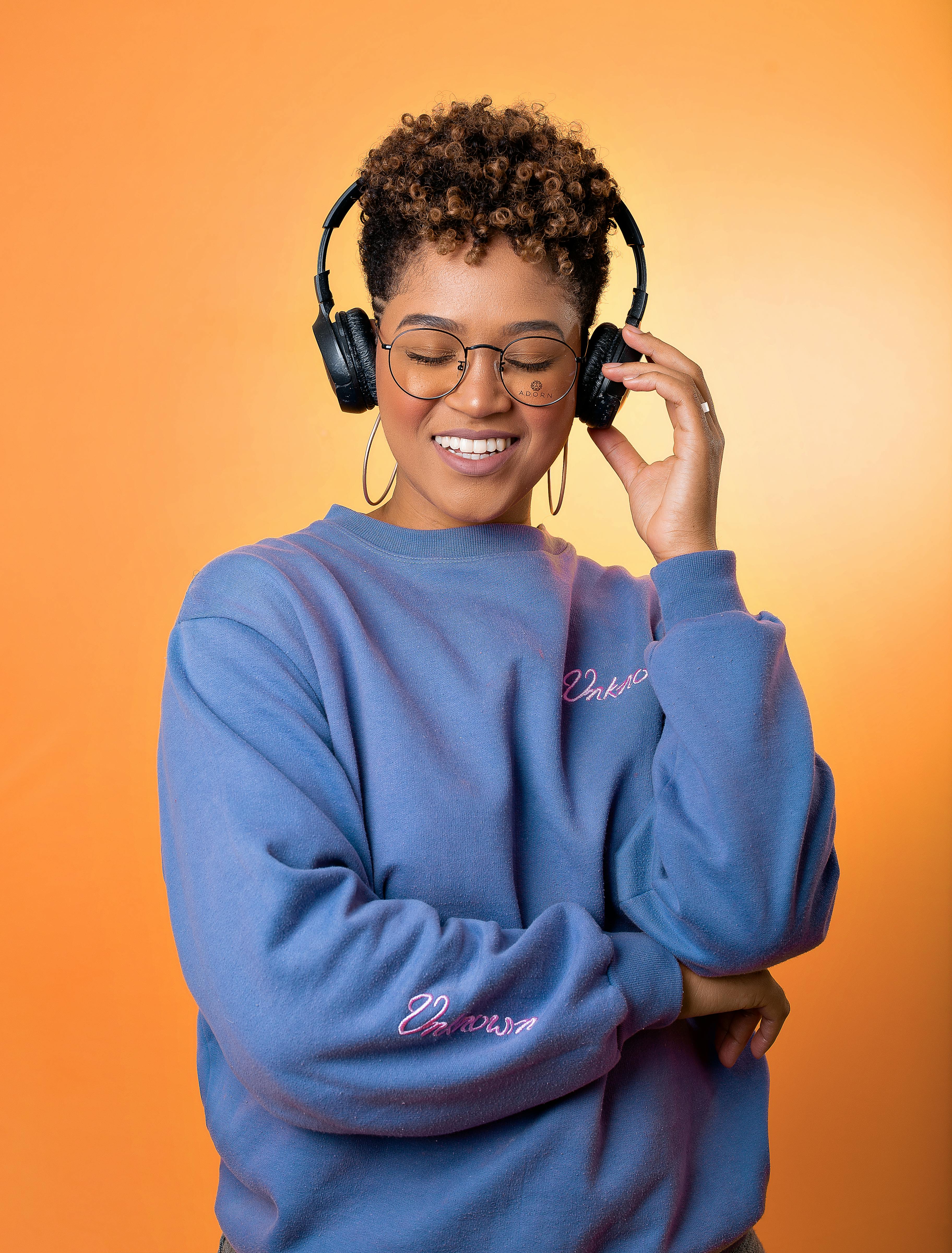 A Woman in Blue Sweater Listening to Music · Free Stock Photo