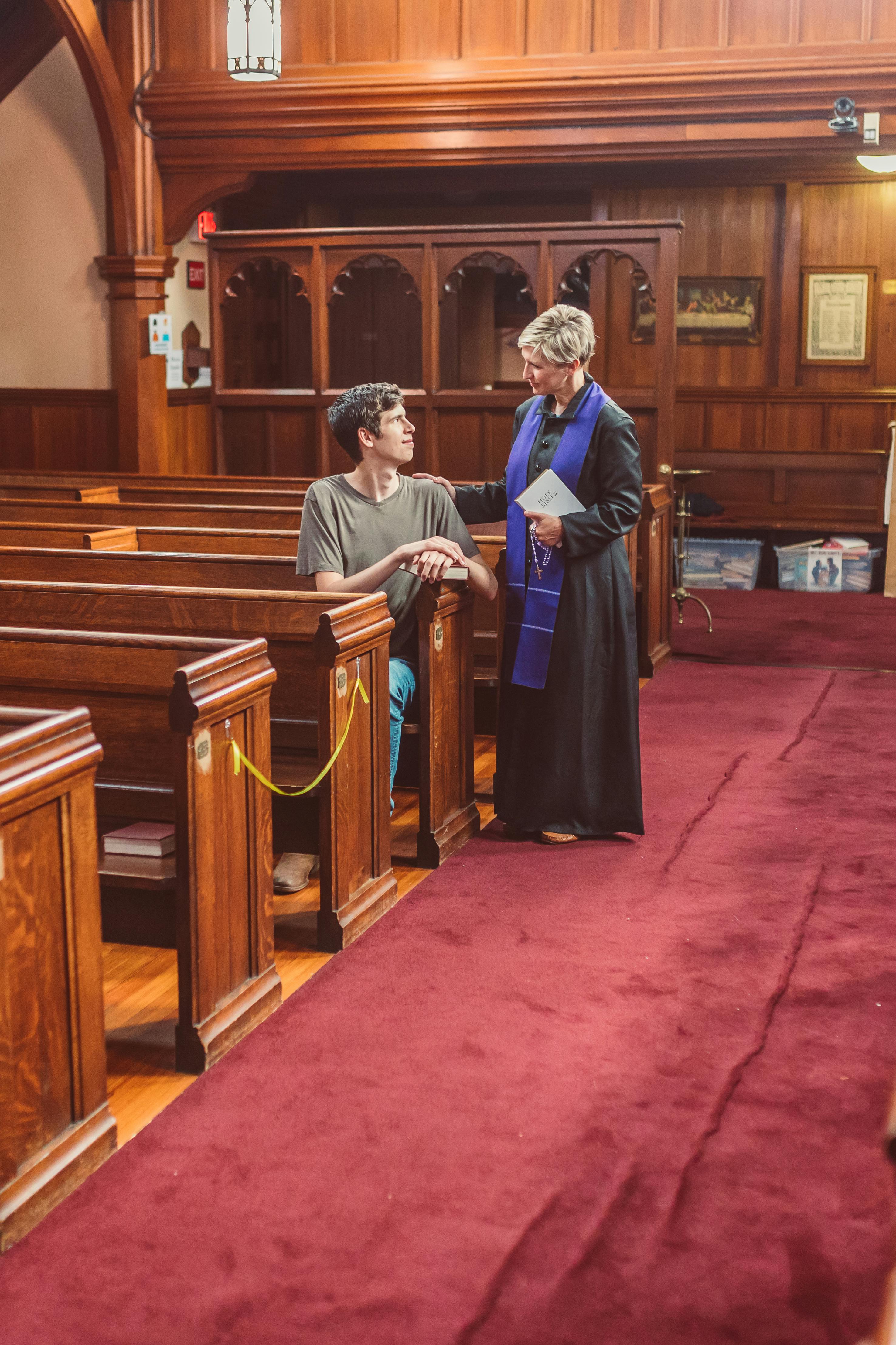 Woman in Black Cassock Comforting a Parishioner · Free Stock Photo
