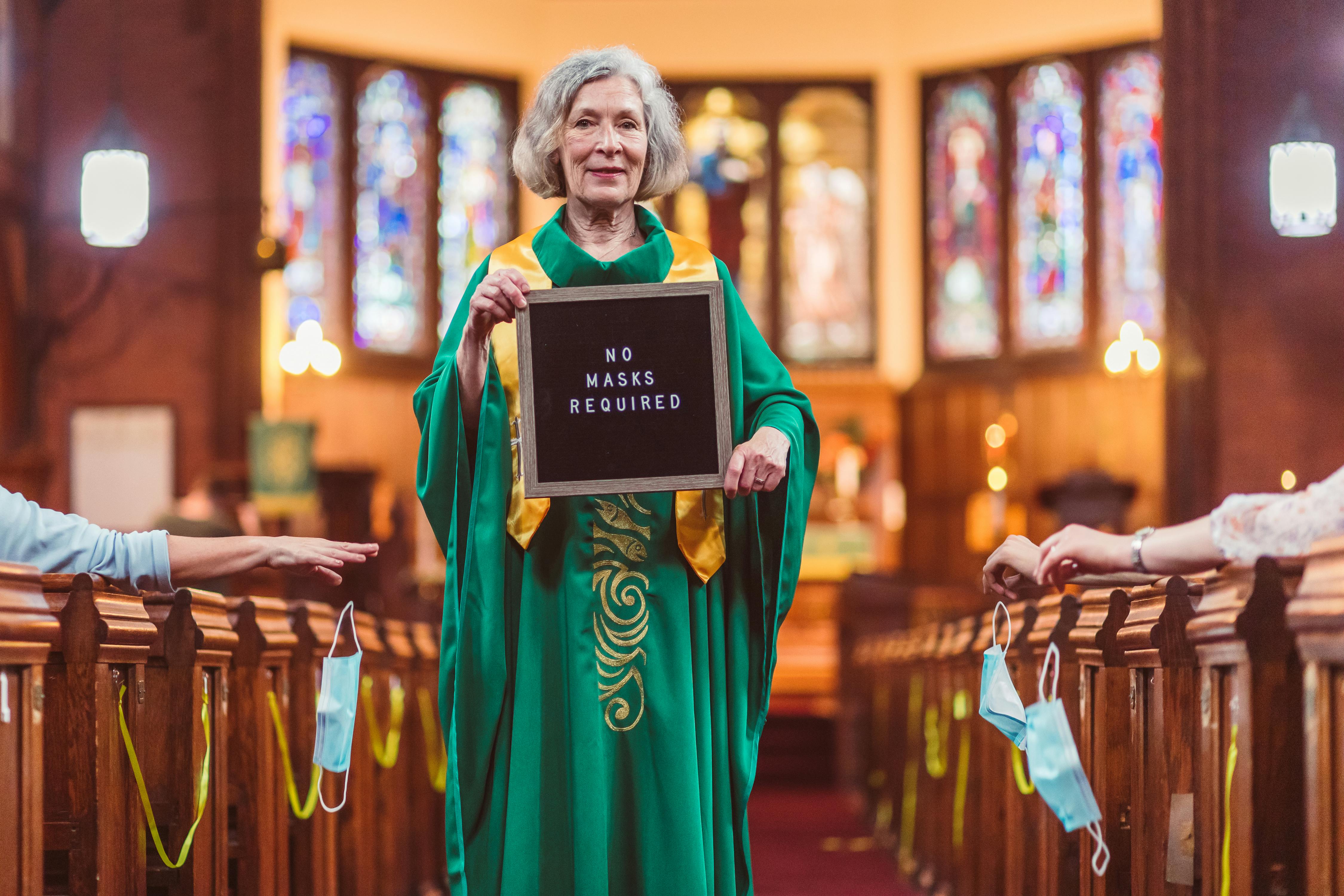 Female Priest Holding a Board · Free Stock Photo